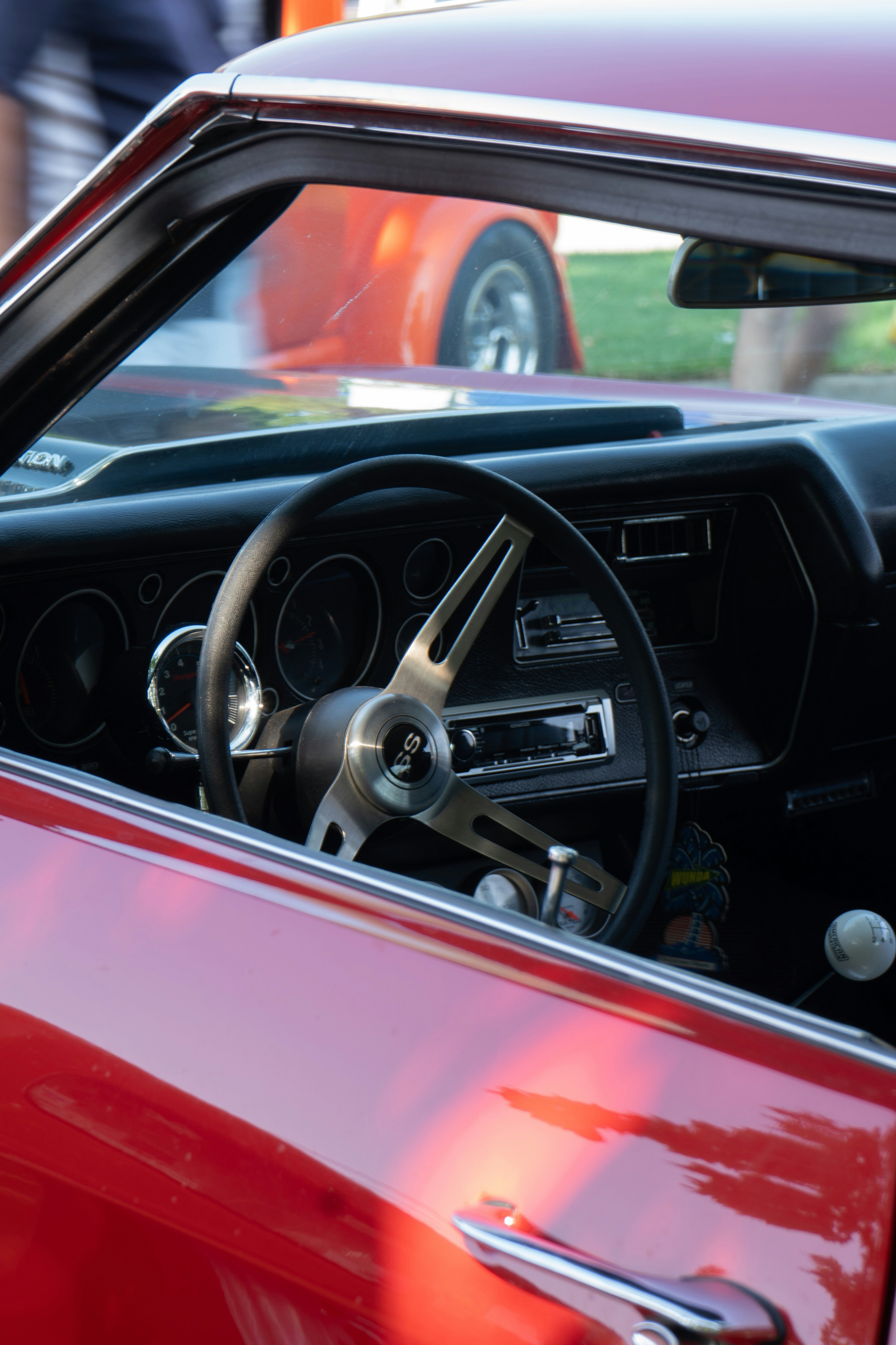 Chrome Steering and Red Classic: A Glimpse Through the Classic Car Window