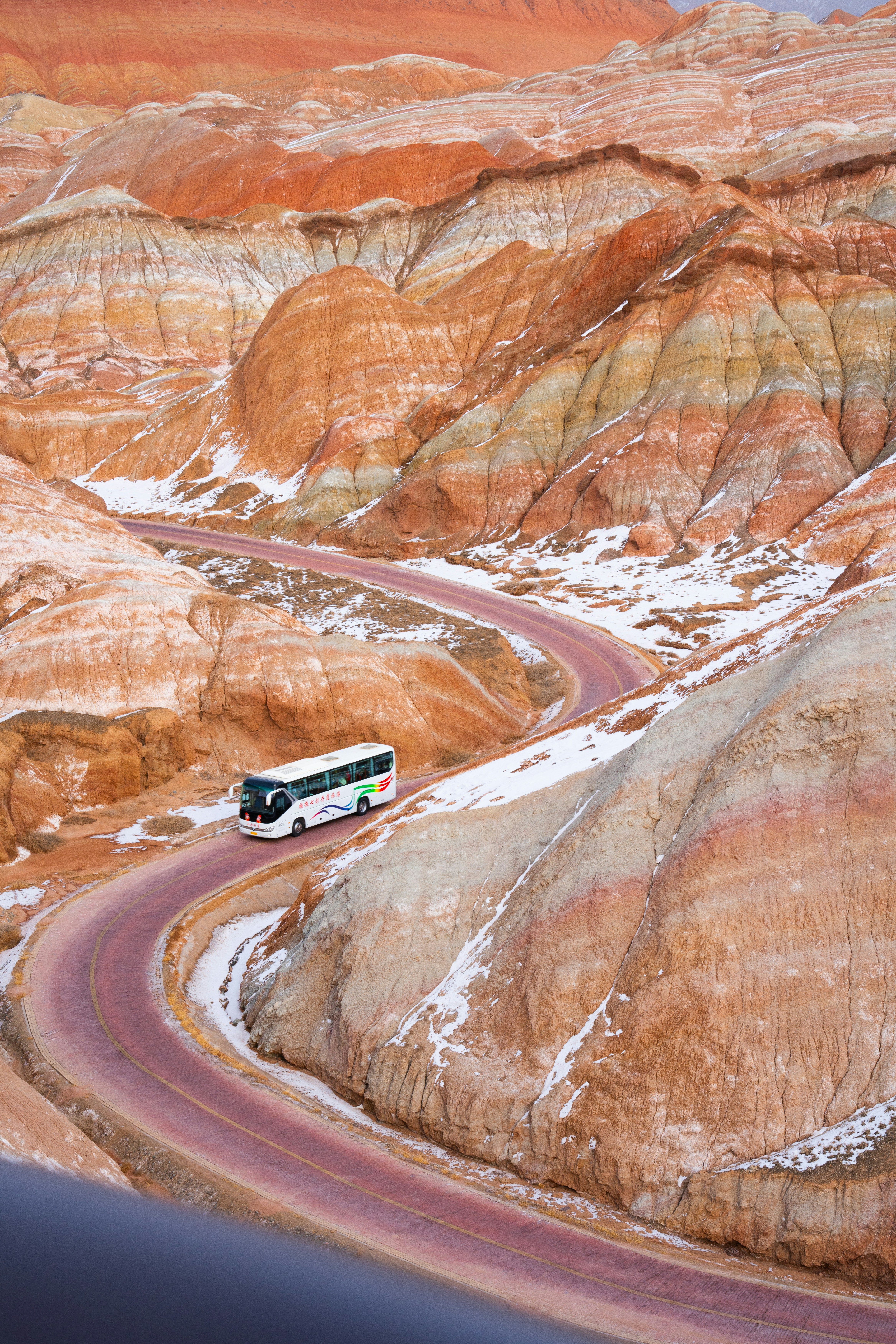 Curving Canyon of Color: A Bus Winds Through Painted Hoodoos