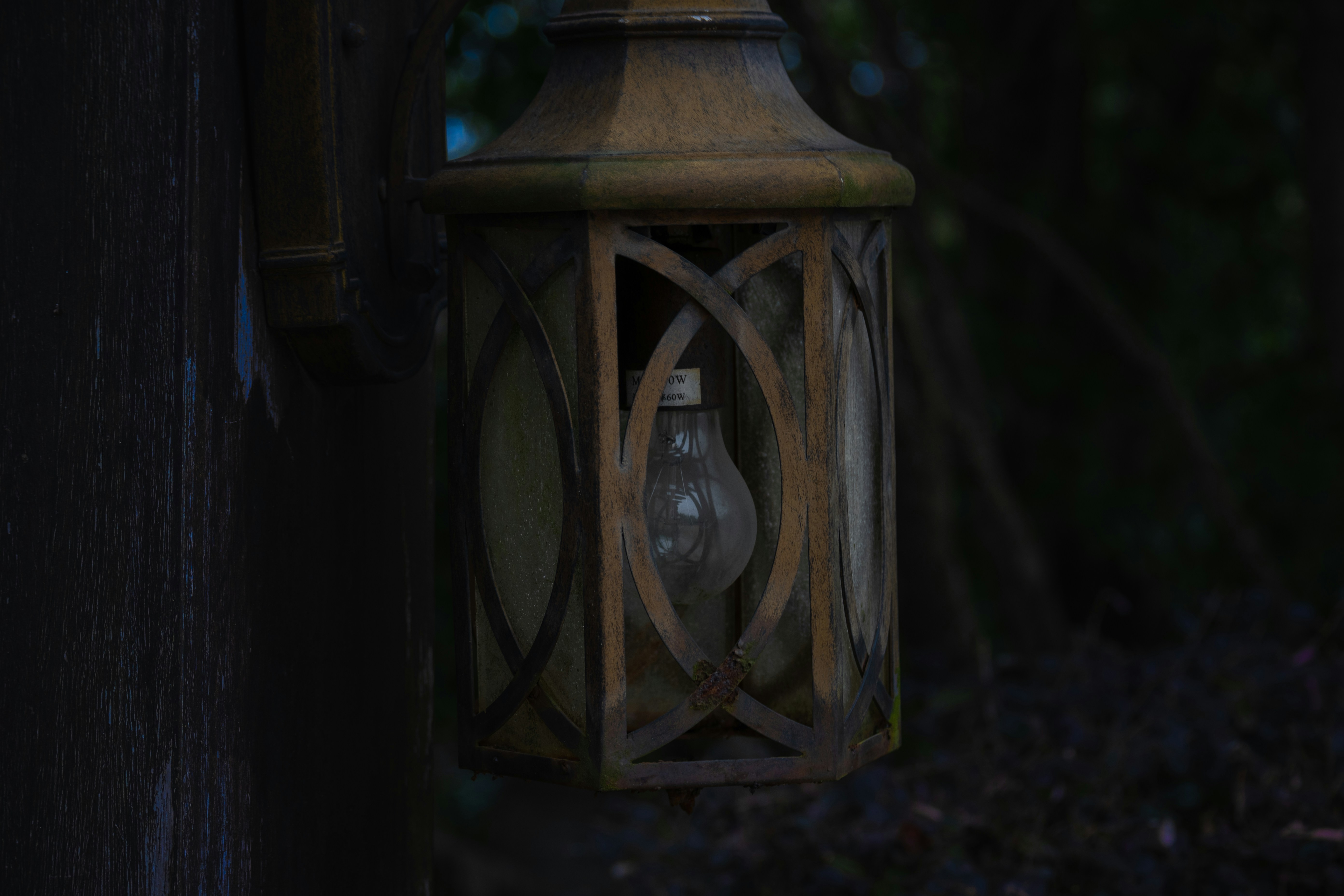 Lattice Lantern in a Night Garden: Quiet Glow Through Rust and Shadow