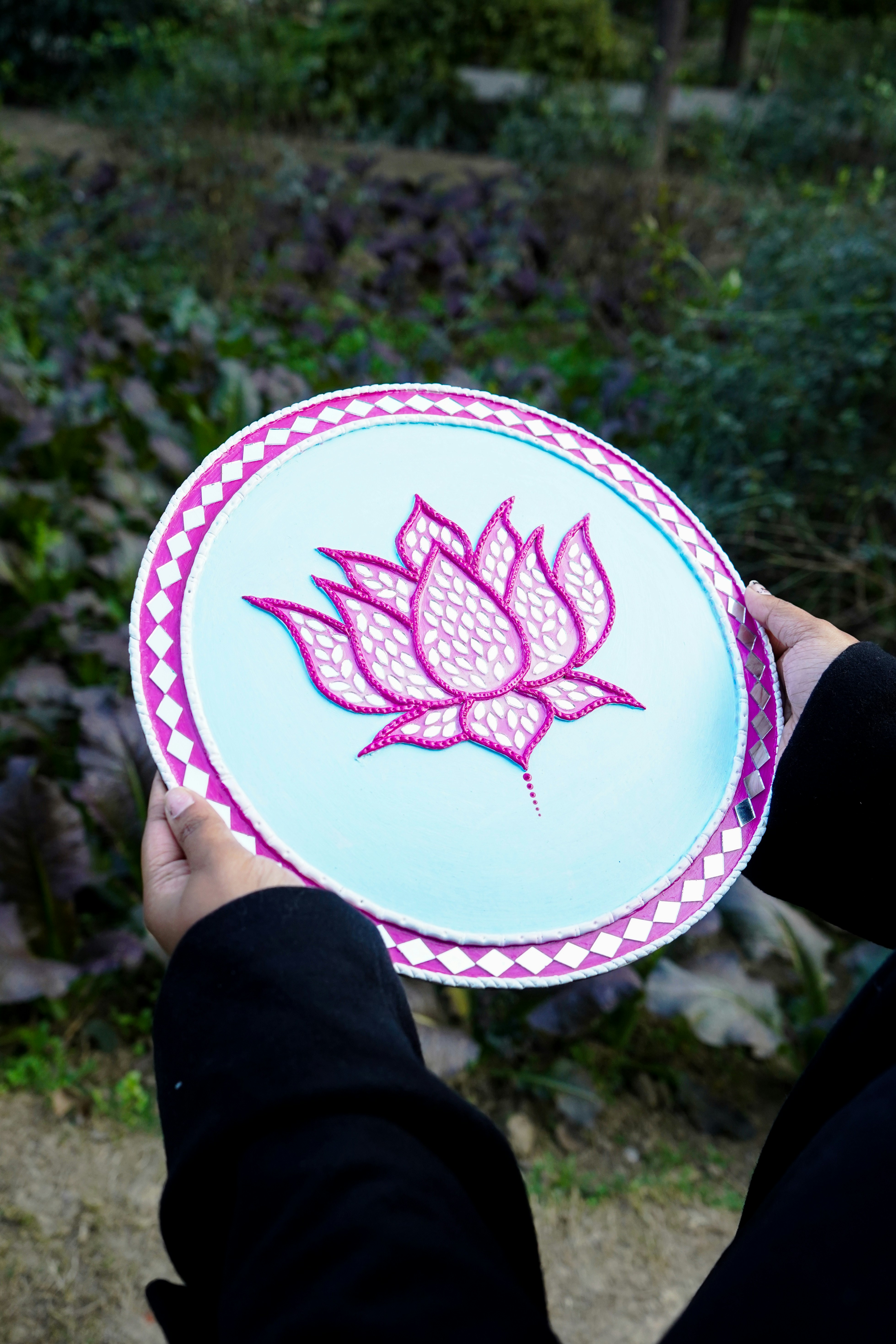 A person holding a paper plate with a picture of a flower on it