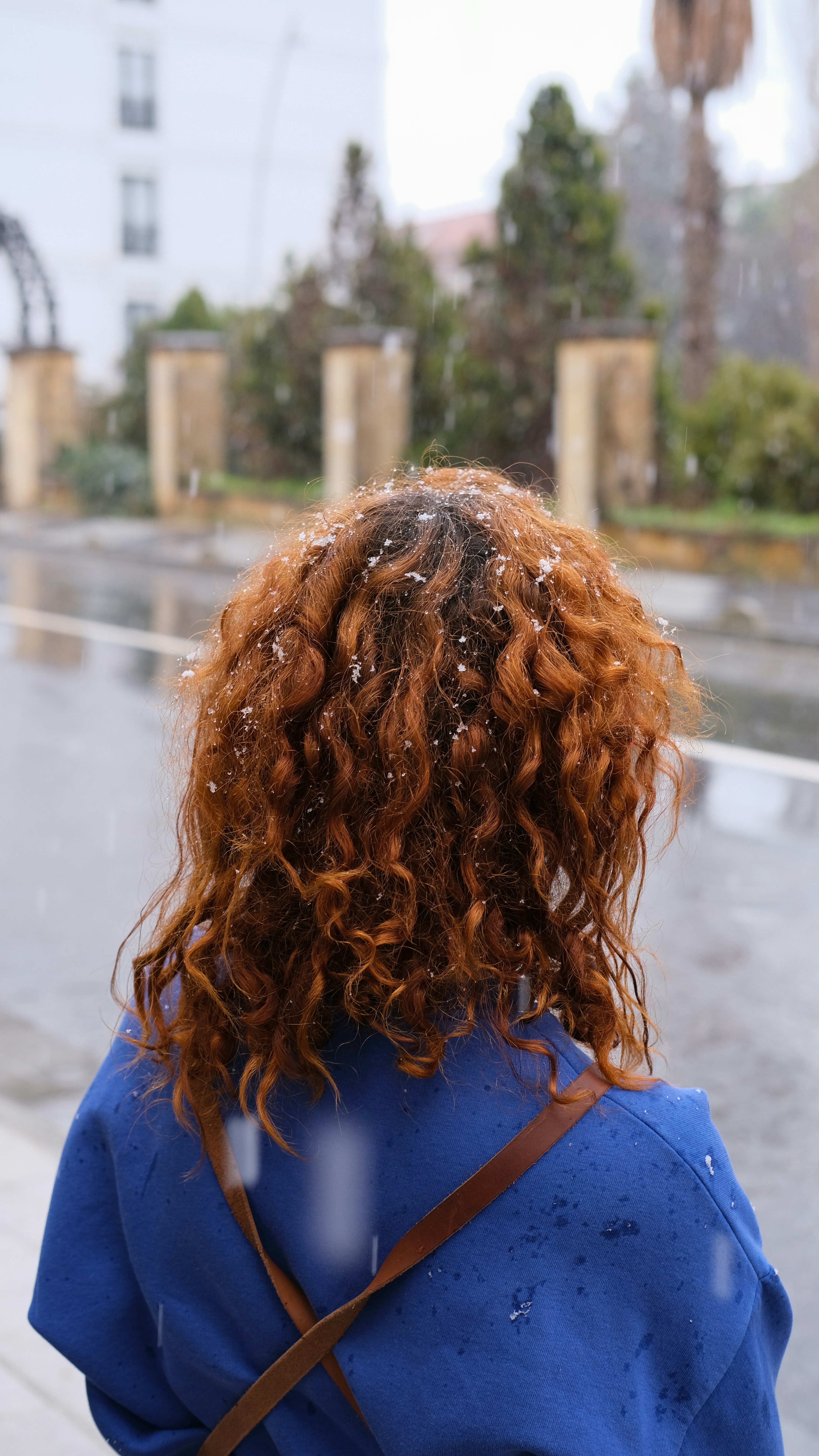 Copper Curls in Rain: A Quiet Street Portrait from Behind