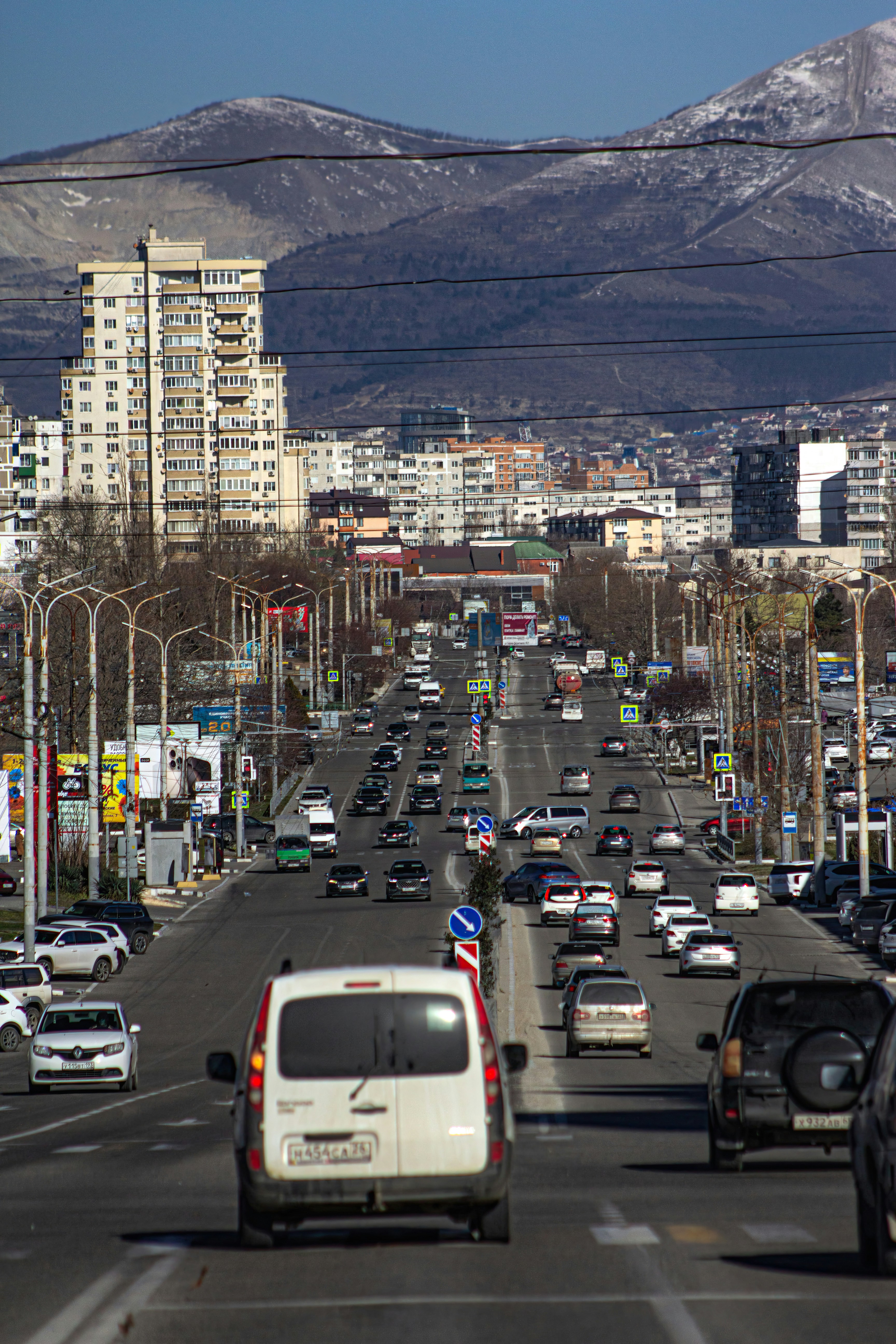 Ridgebound Commute: A Busy Boulevard Framed by Snow-Capped Peaks
