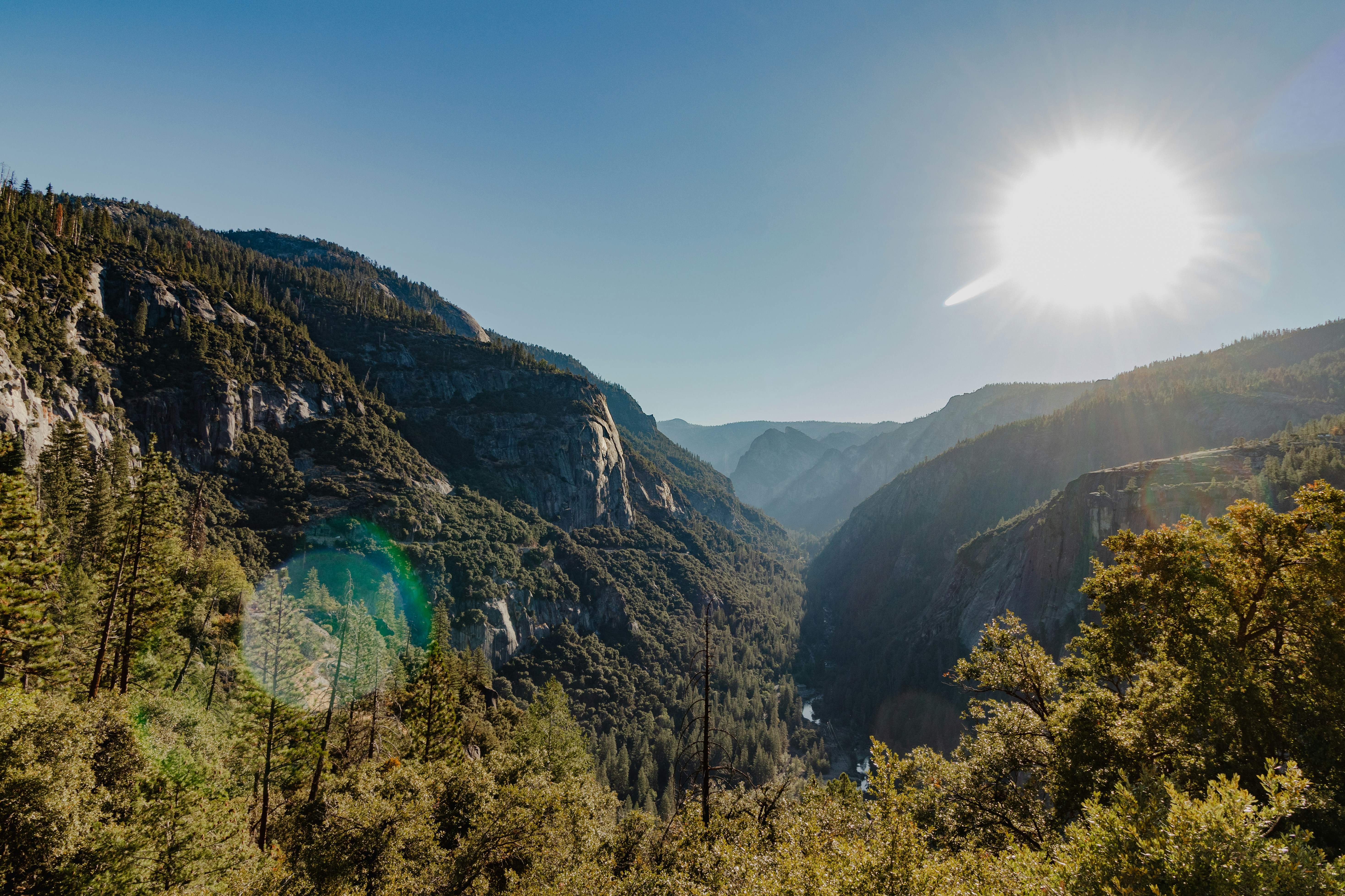 The sun shines brightly over a valley in the mountains photo – Free ...