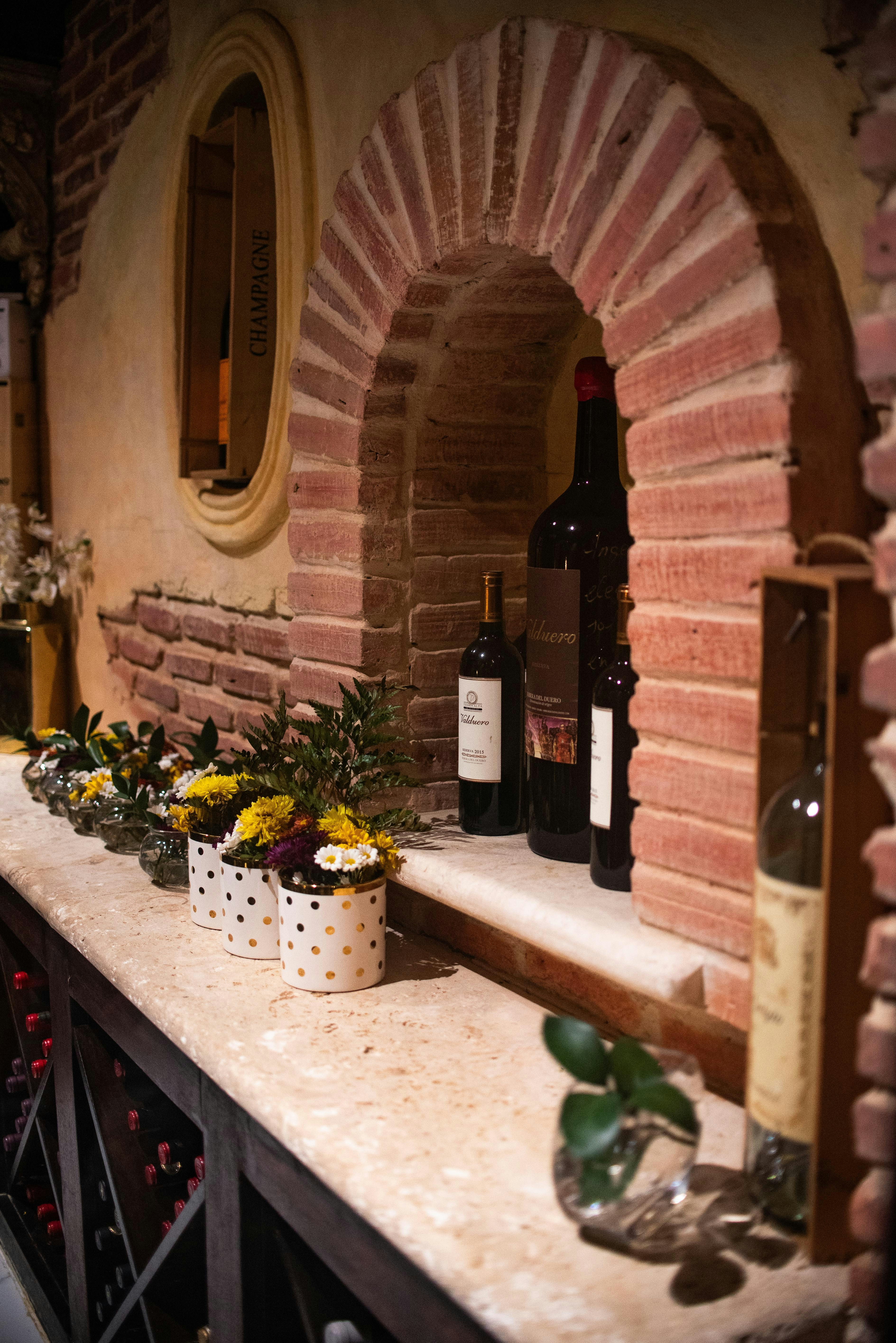 Archway of Quiet Red: Bottles Nestled in a Brick Nook