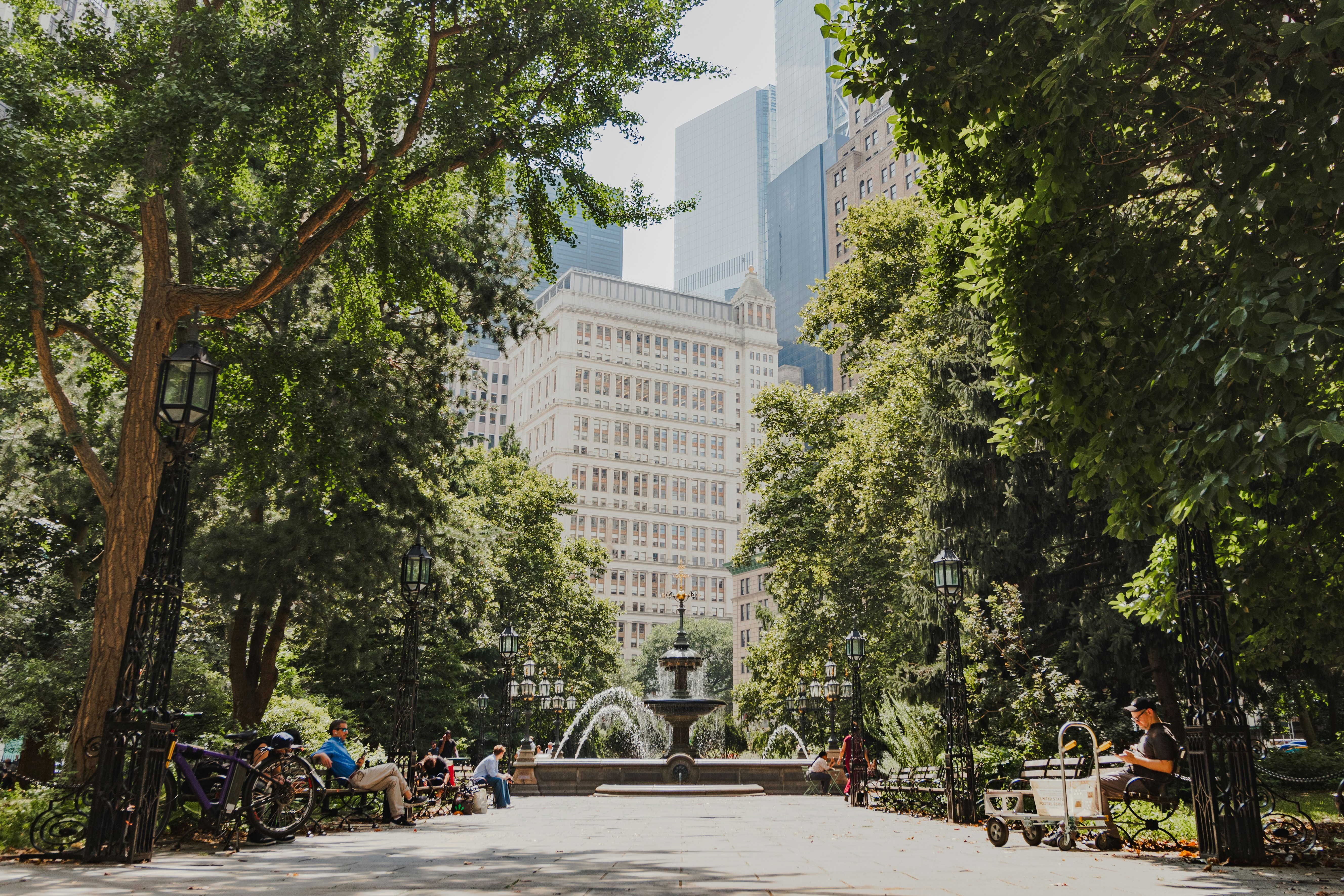 A group of people sitting on benches in a park photo – Free New york ...