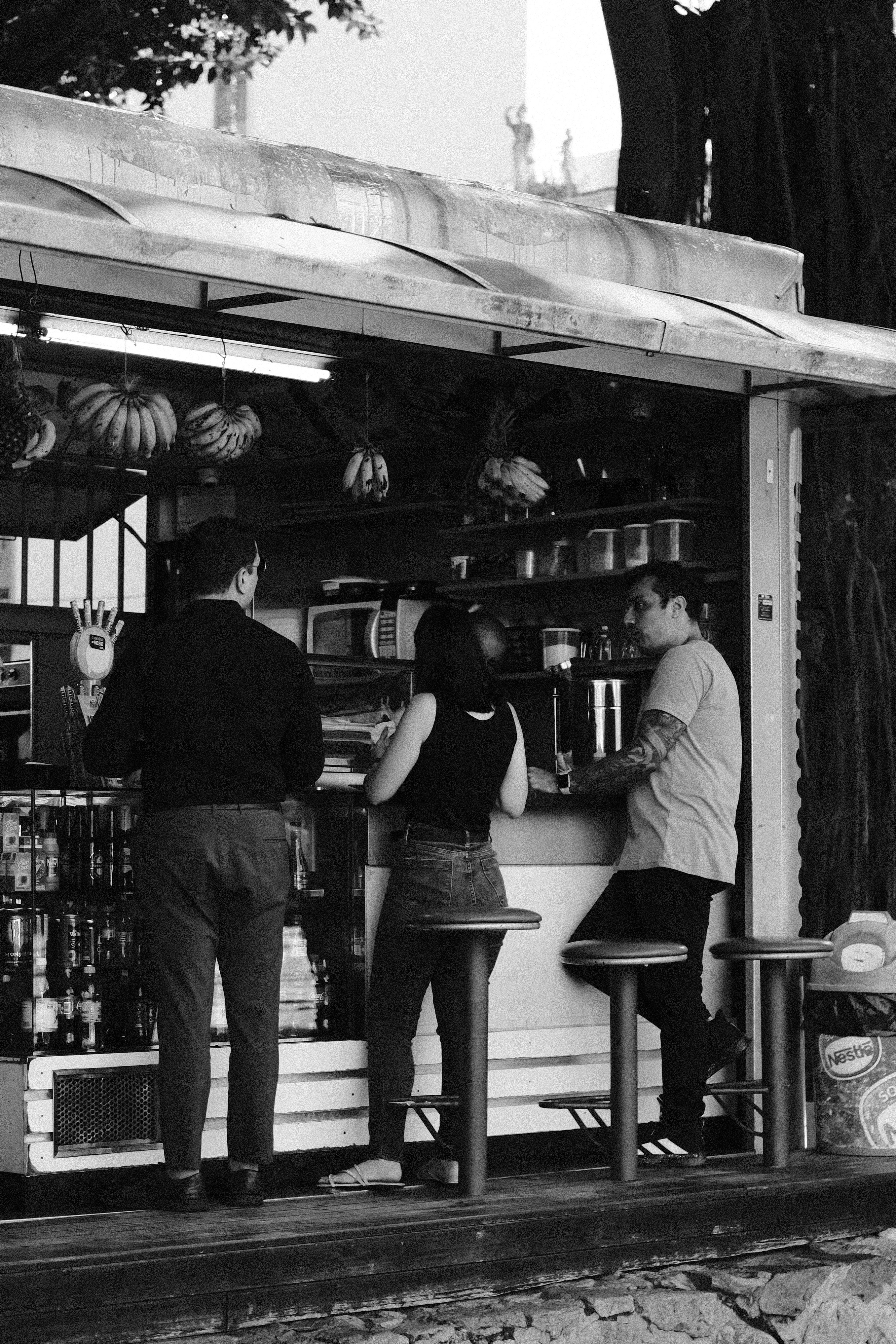 A black and white photo of people ordering food