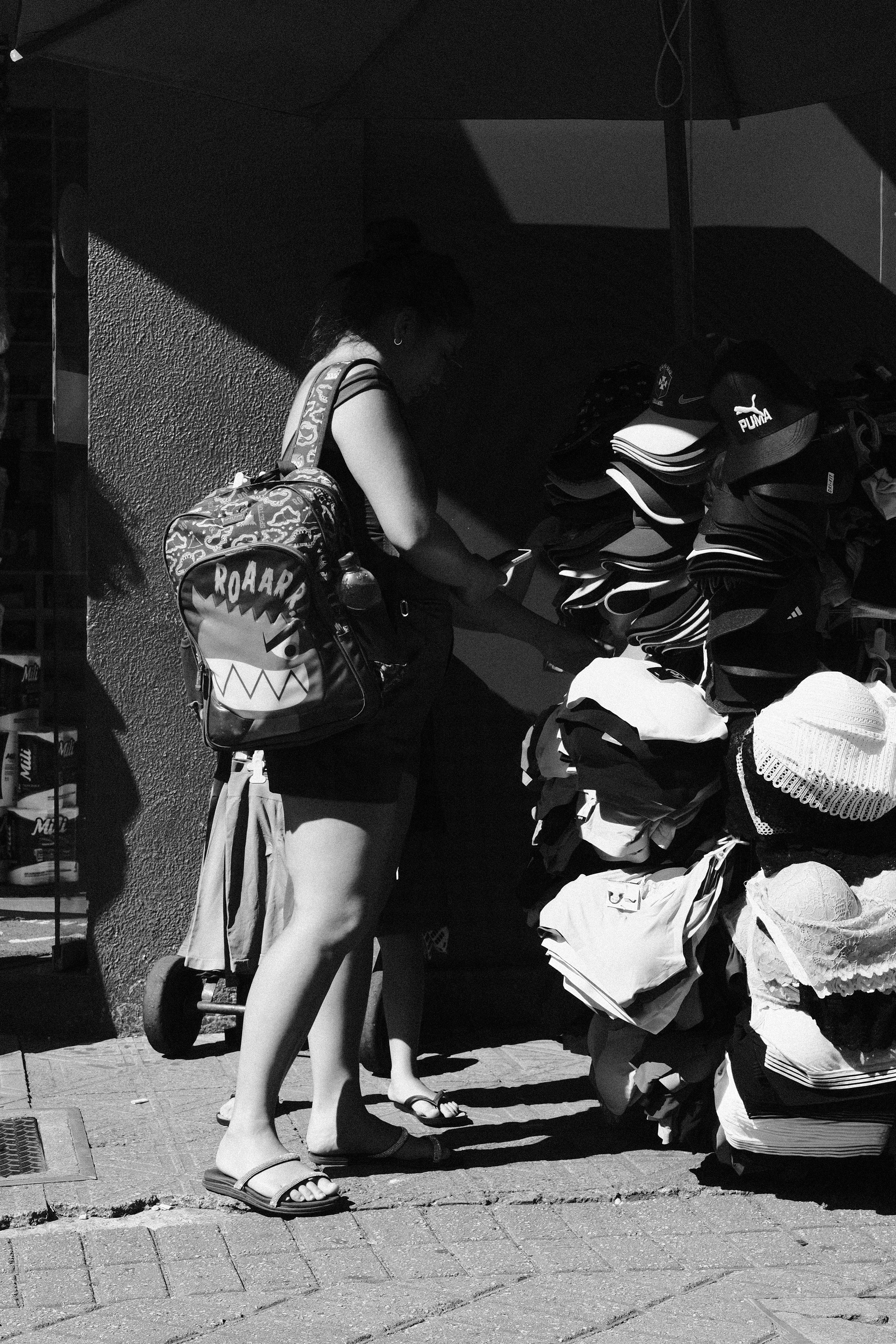 A woman standing next to a pile of hats