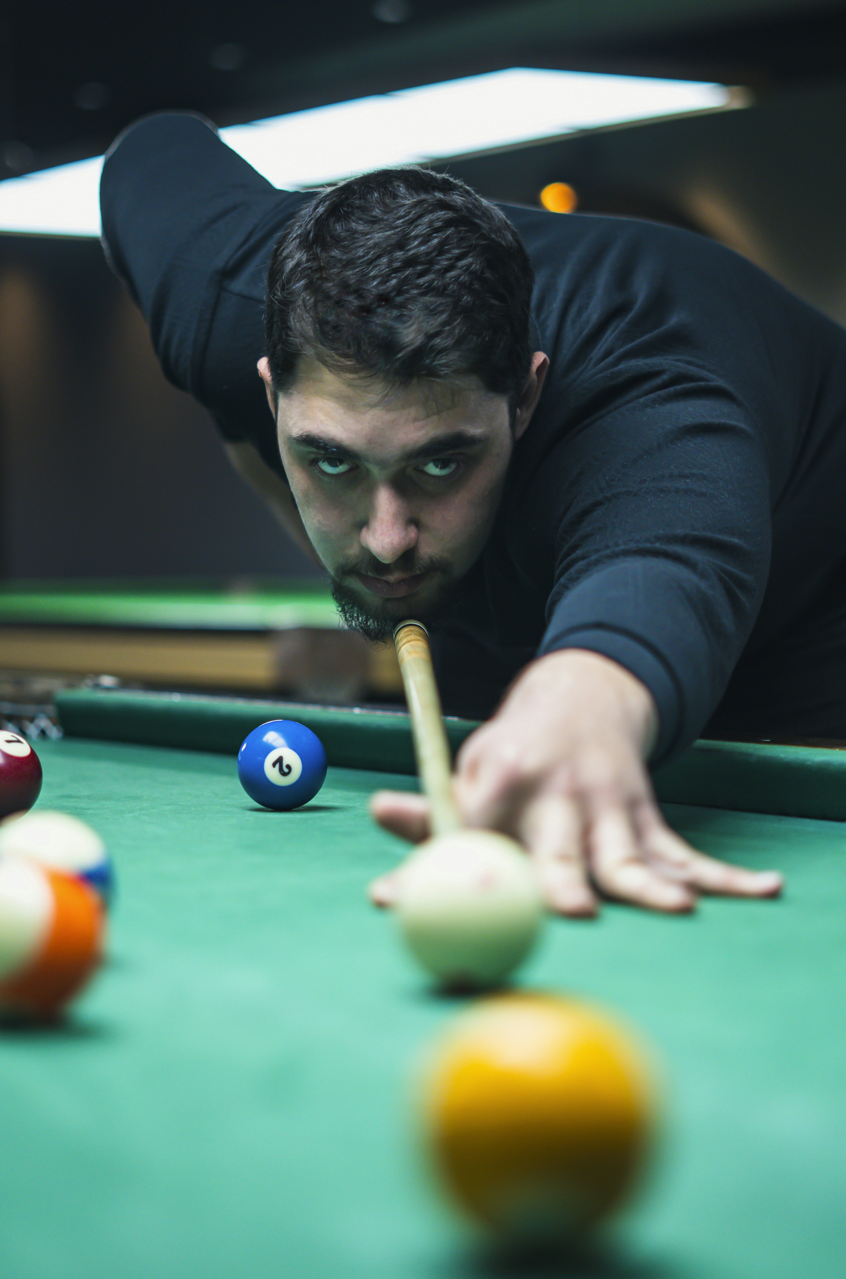 A man leaning over a pool table with a cue in his hand photo – Free ...
