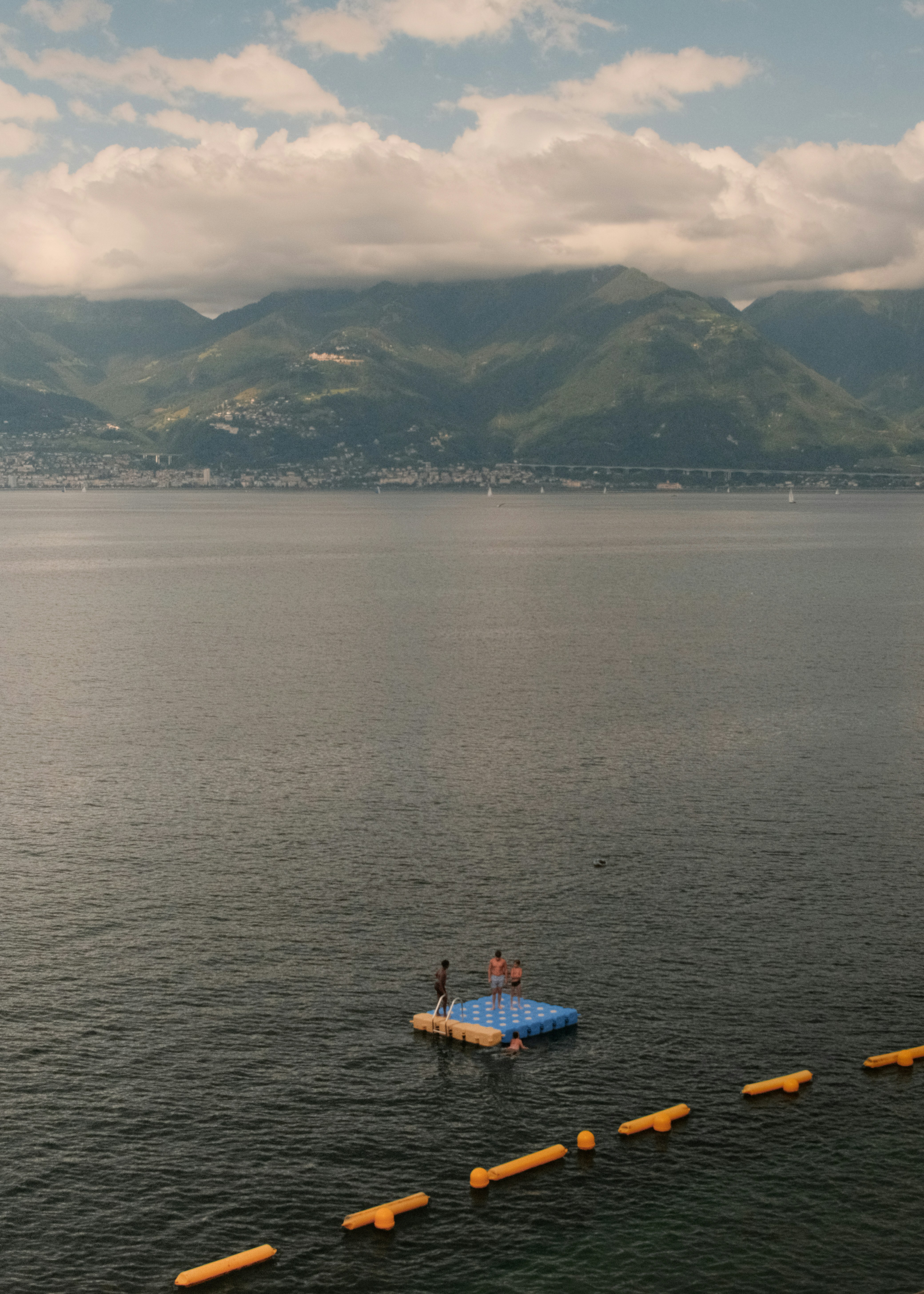 Calm Confluence: A Blue Platform Anchored in a Lake Among Alpine Peaks