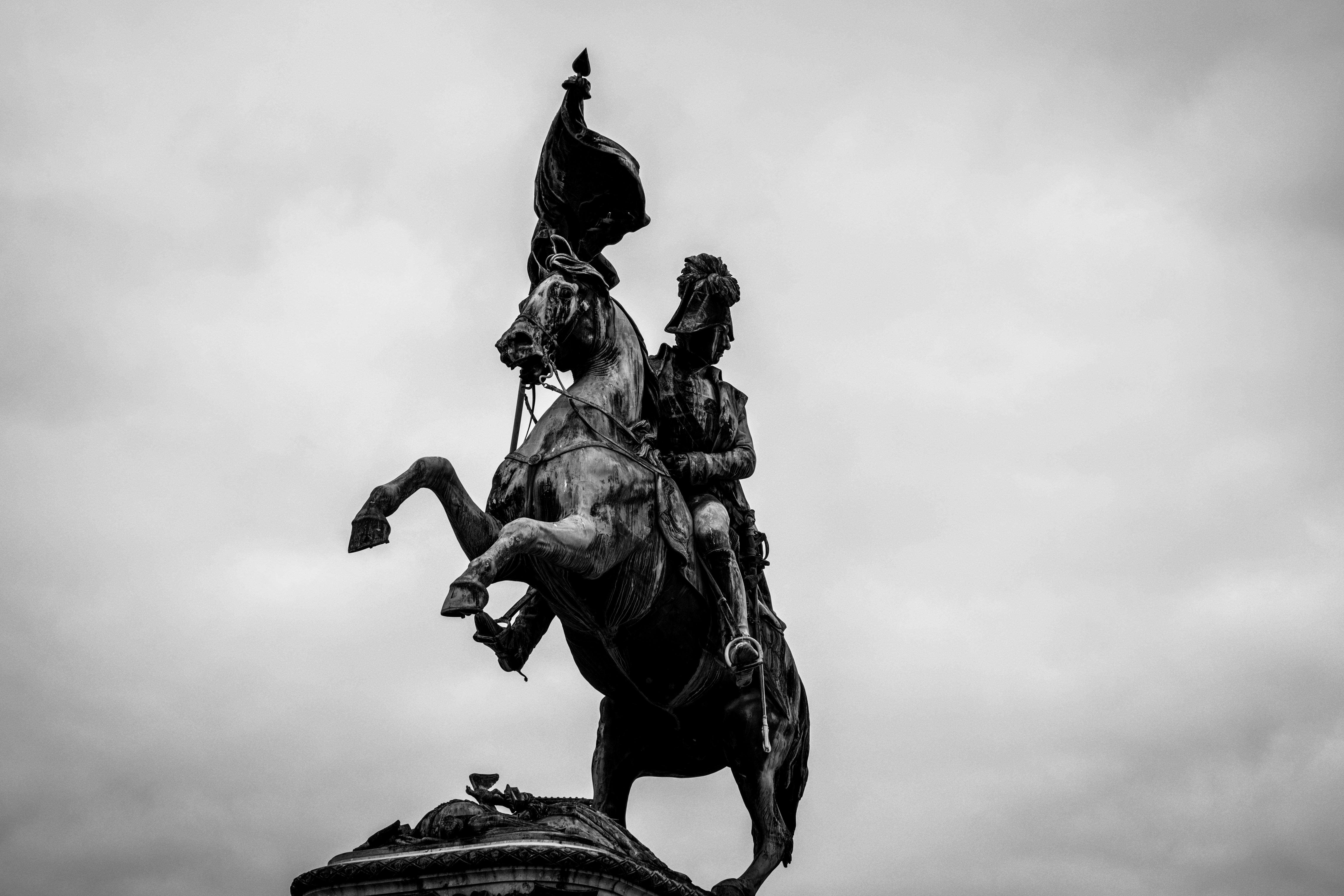 Equestrian statue silhouetted against a cloudy sky, capturing a sense of historical grandeur.