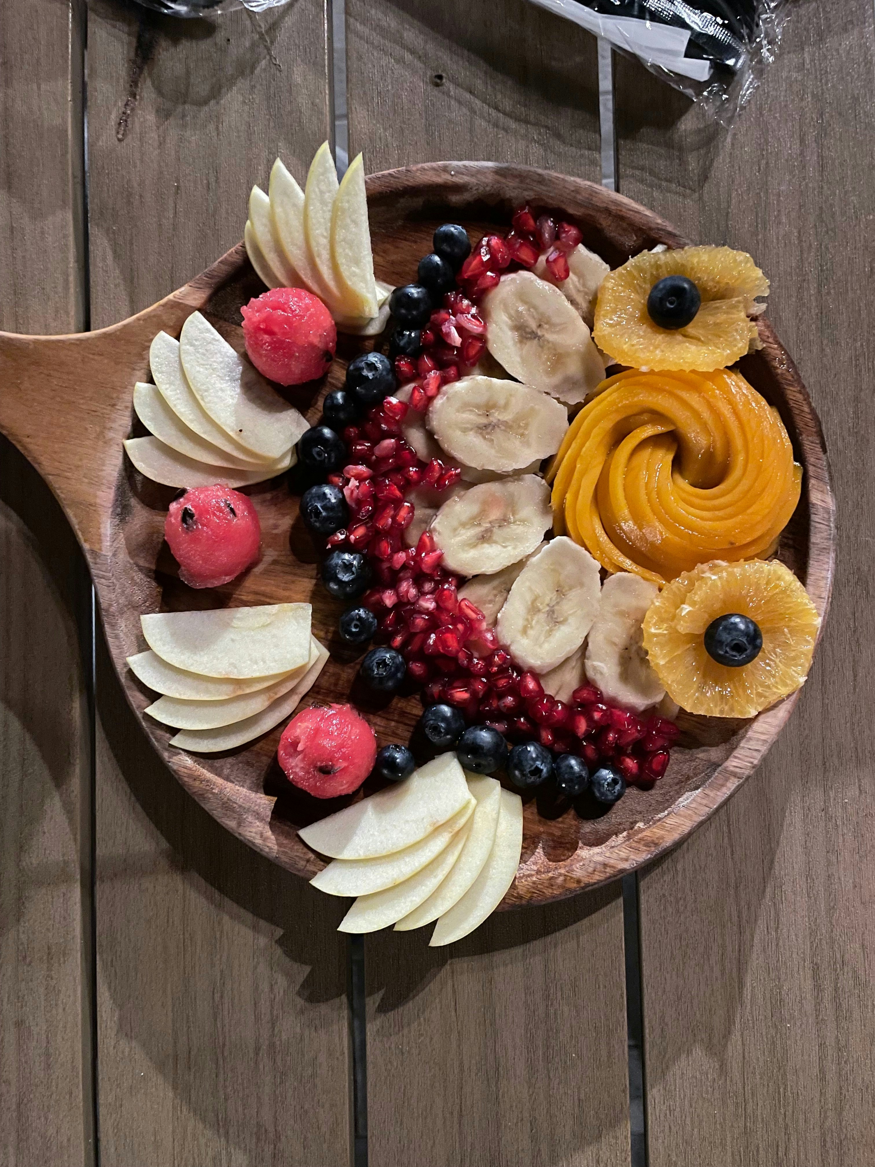 Fruit Carousel on a Wooden Plate: Mango Swirl, Banana Rosettes, and Berry Accents