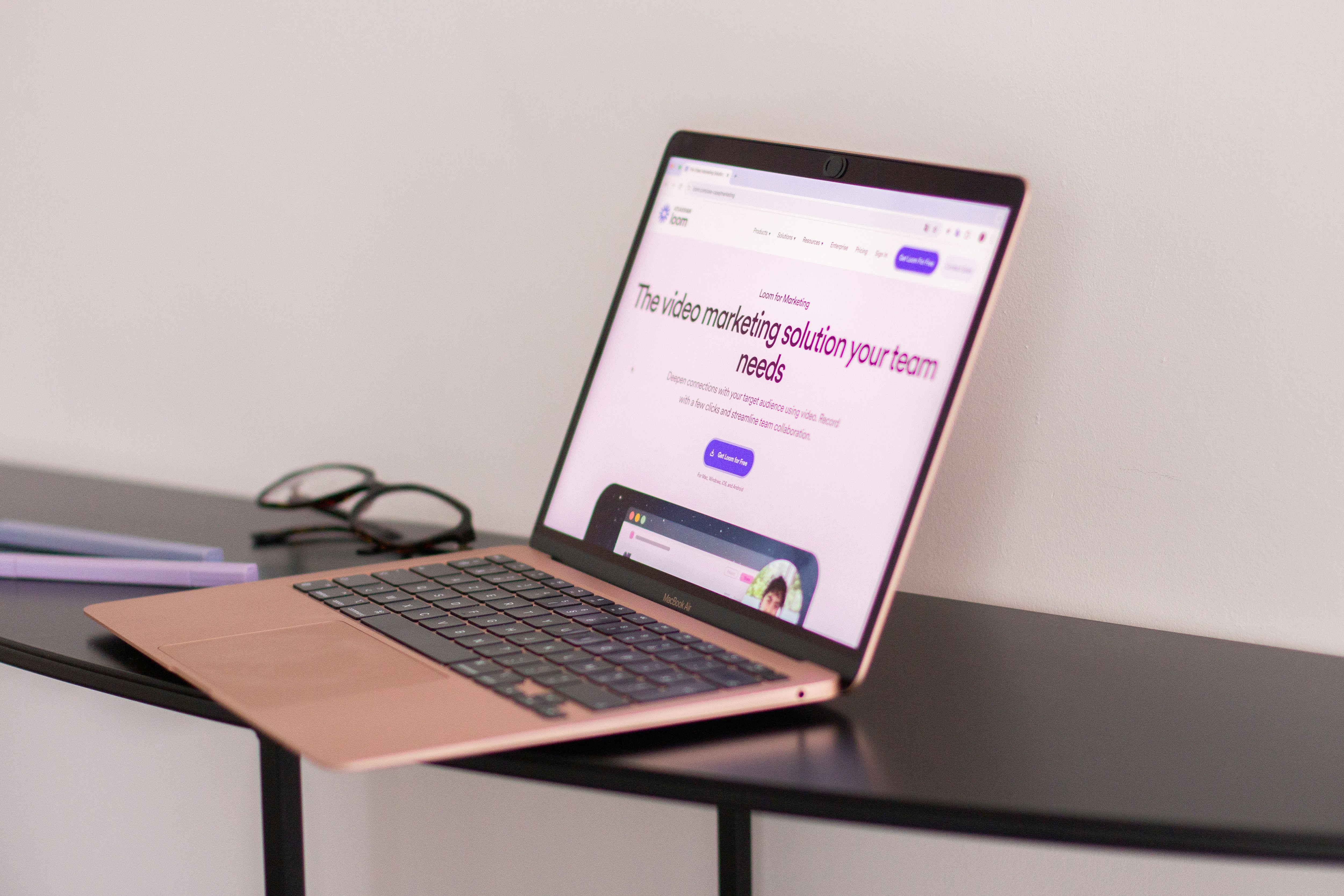 Open laptop on sleek black desk displaying a marketing software interface.