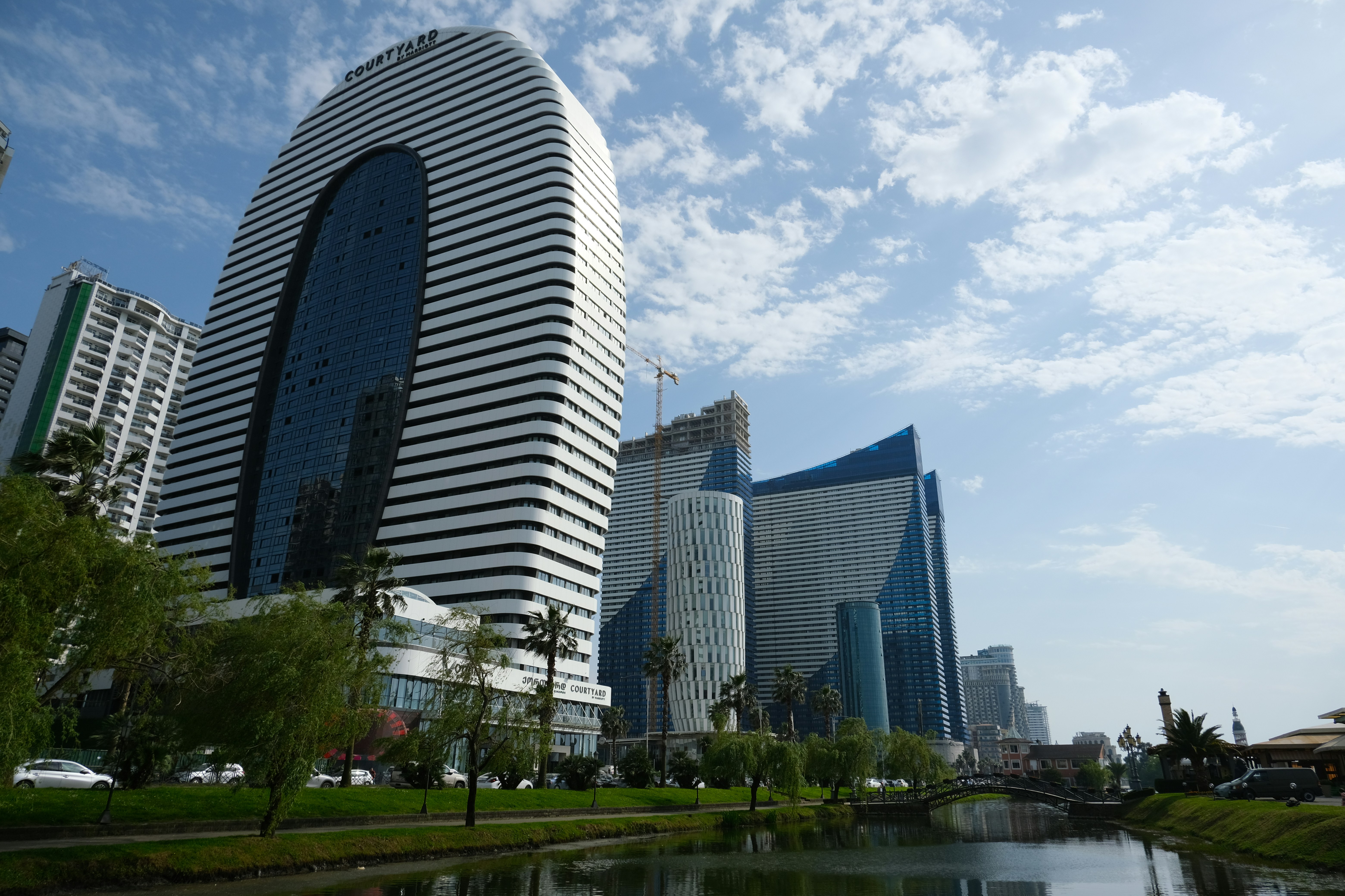 Curved White Tower Anchoring a Modern Waterfront Skyline