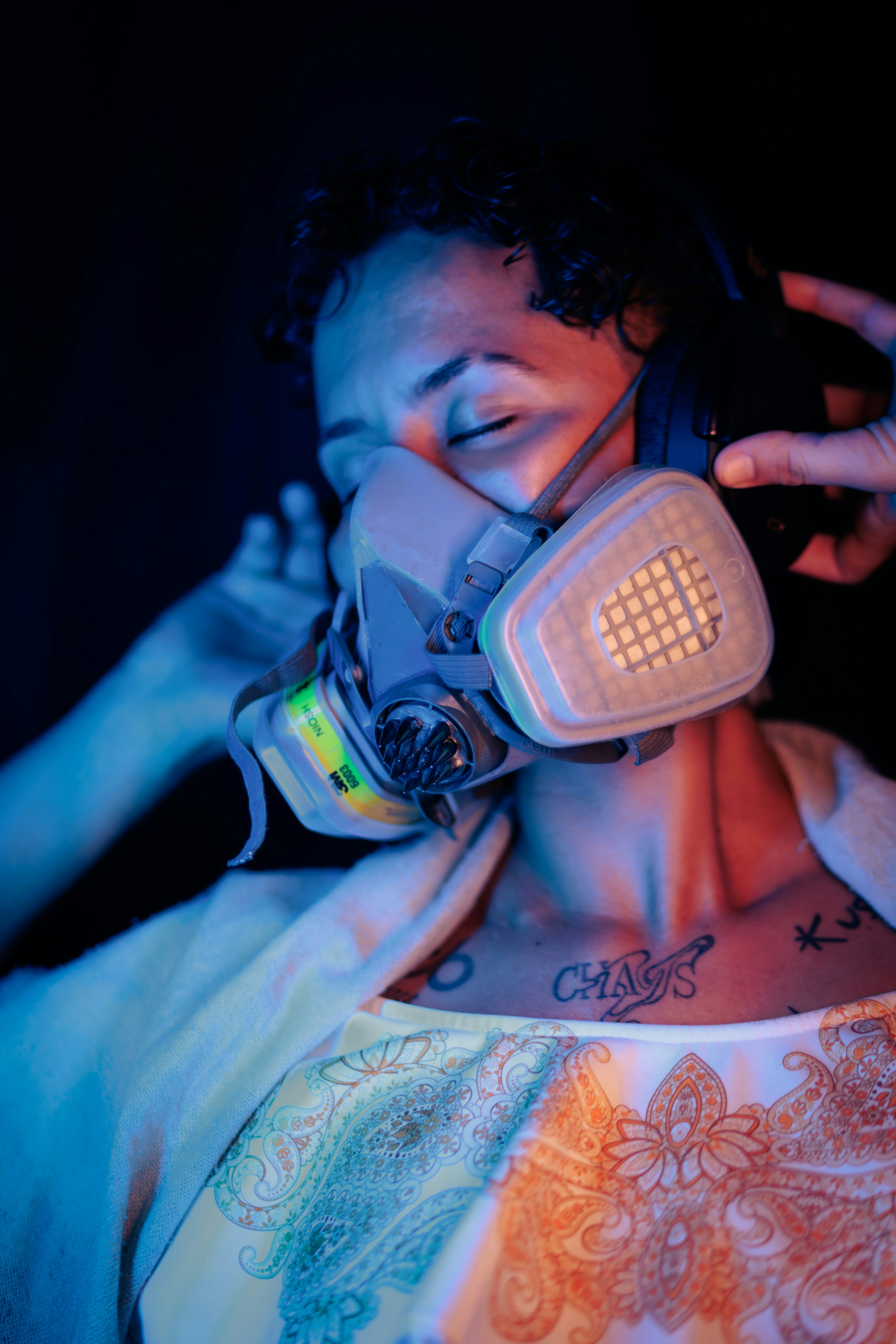 Masked moment under blue glow: a guitarist prepares to perform