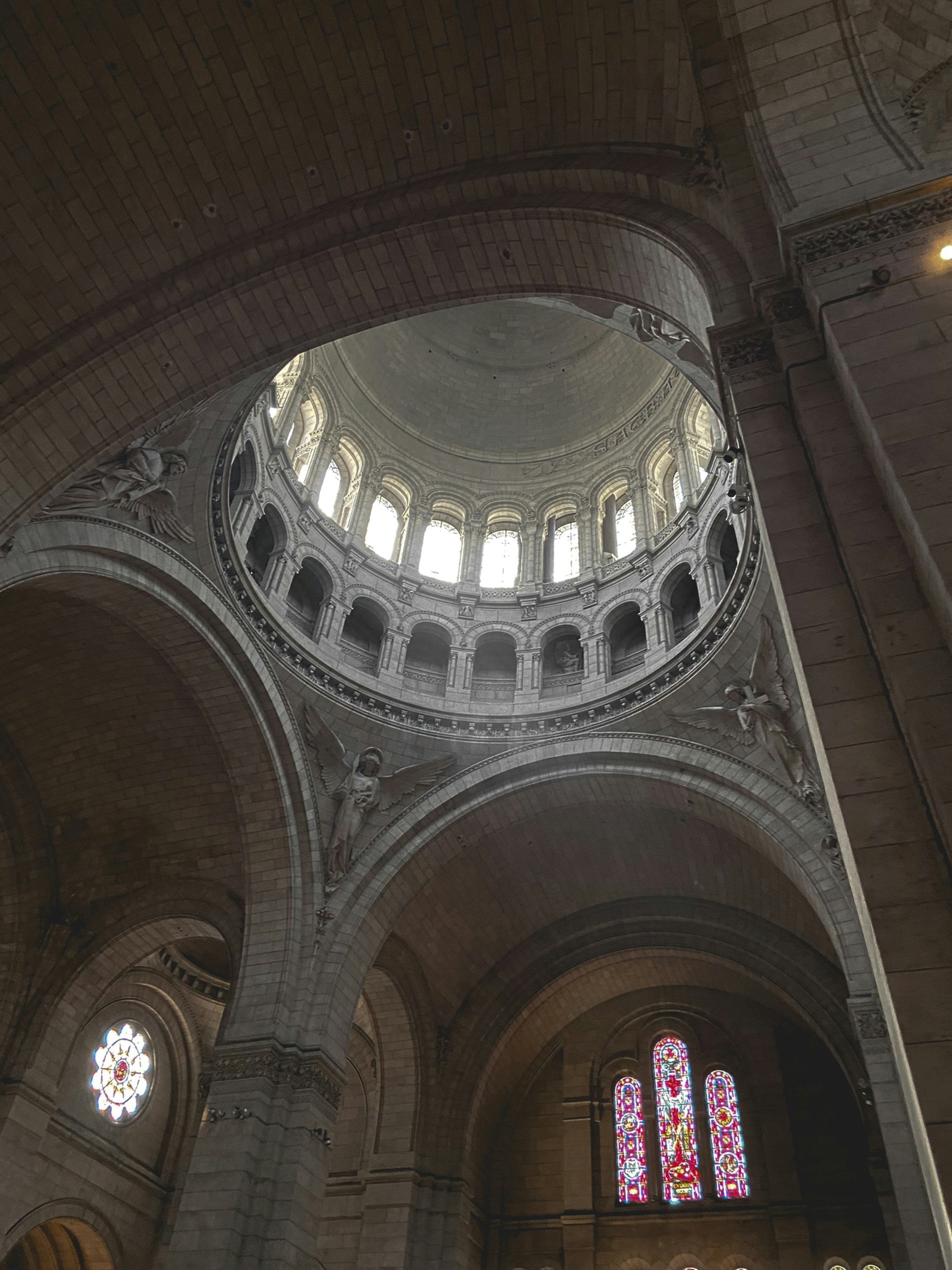 A large cathedral with high vaulted ceilings and stained glass windows ...