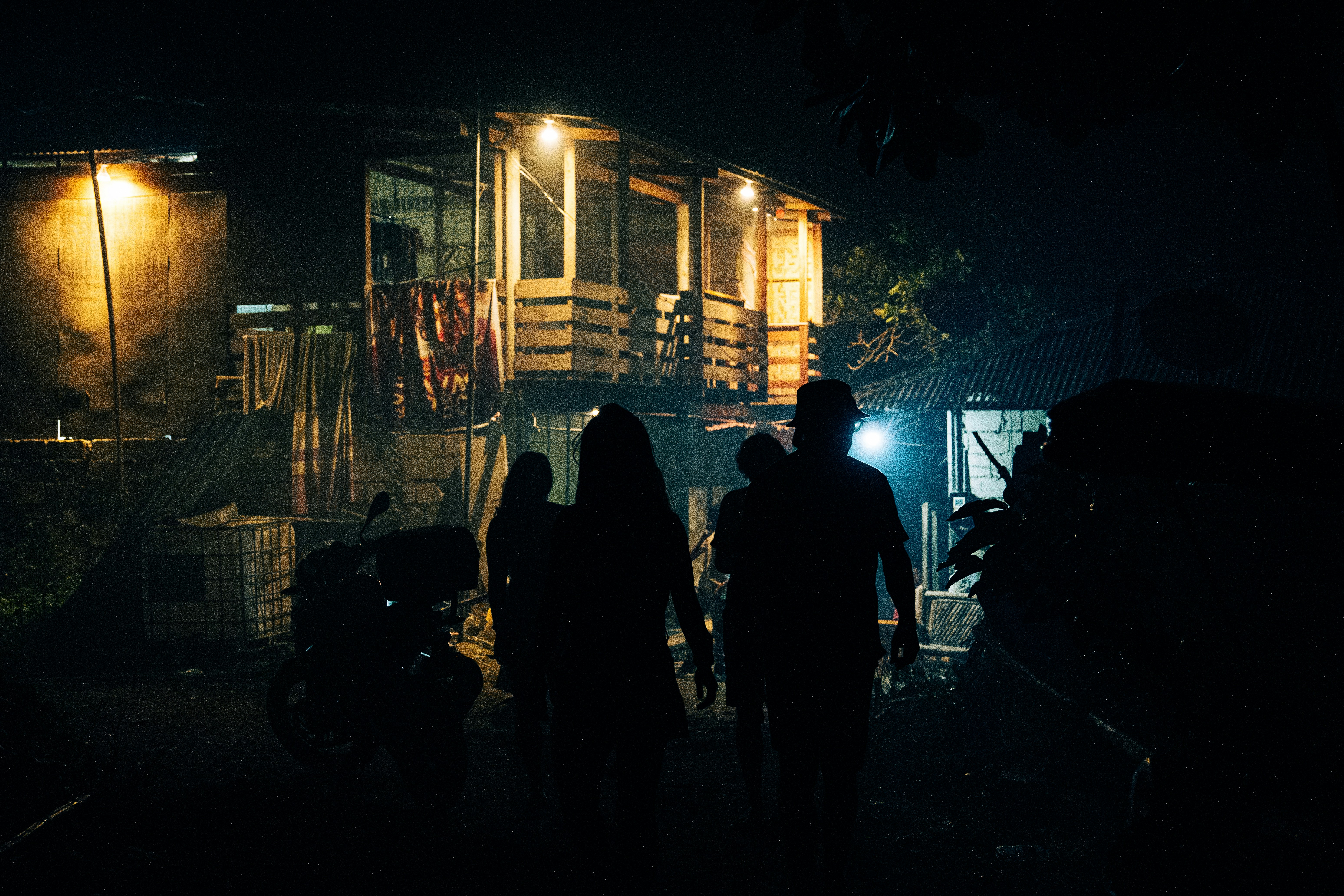 A group of people standing outside of a house at night photo – Free ...