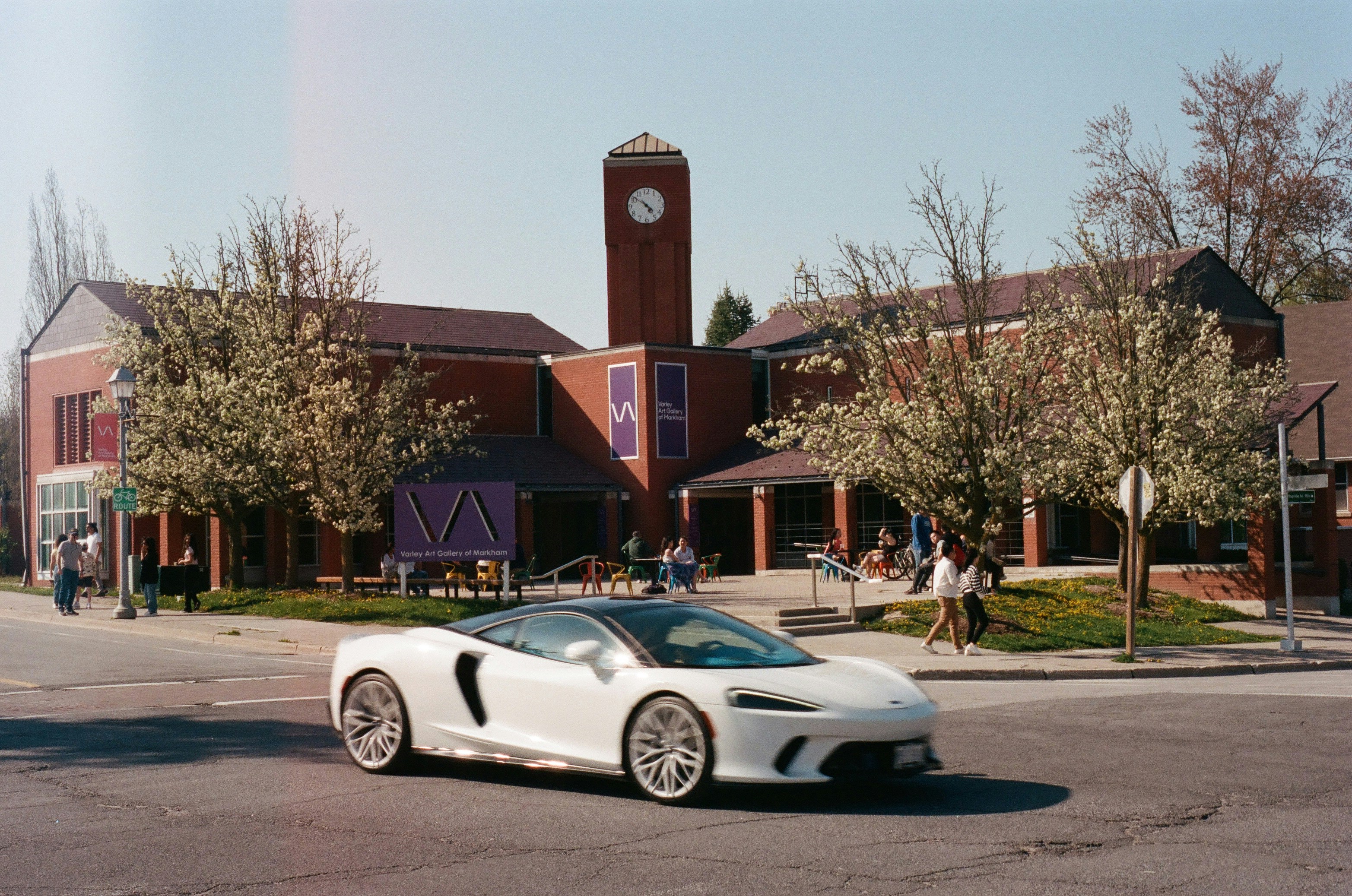 A white sports car parked in front of a building