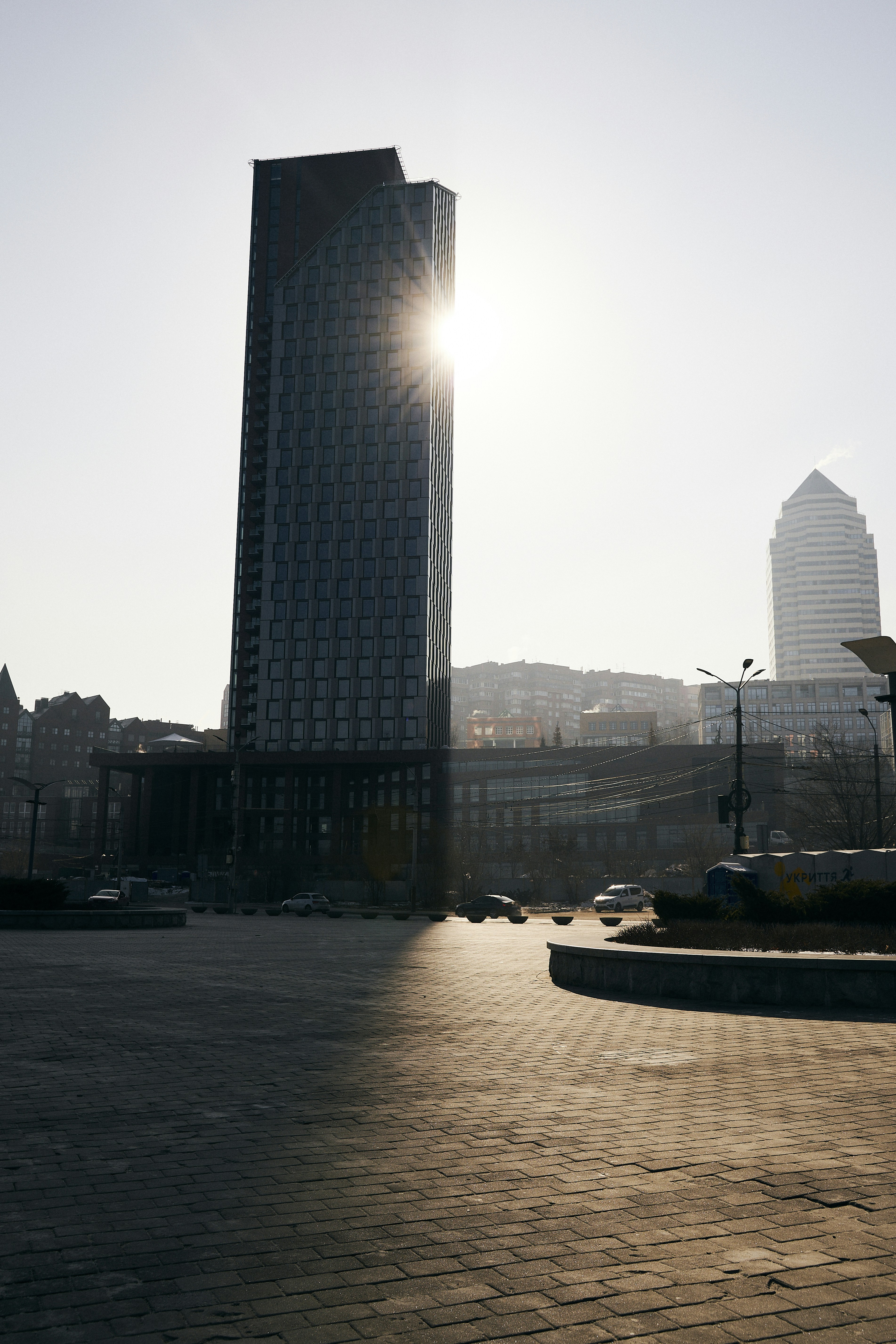 Sunburst on a Glass Tower Over a Quiet City Plaza