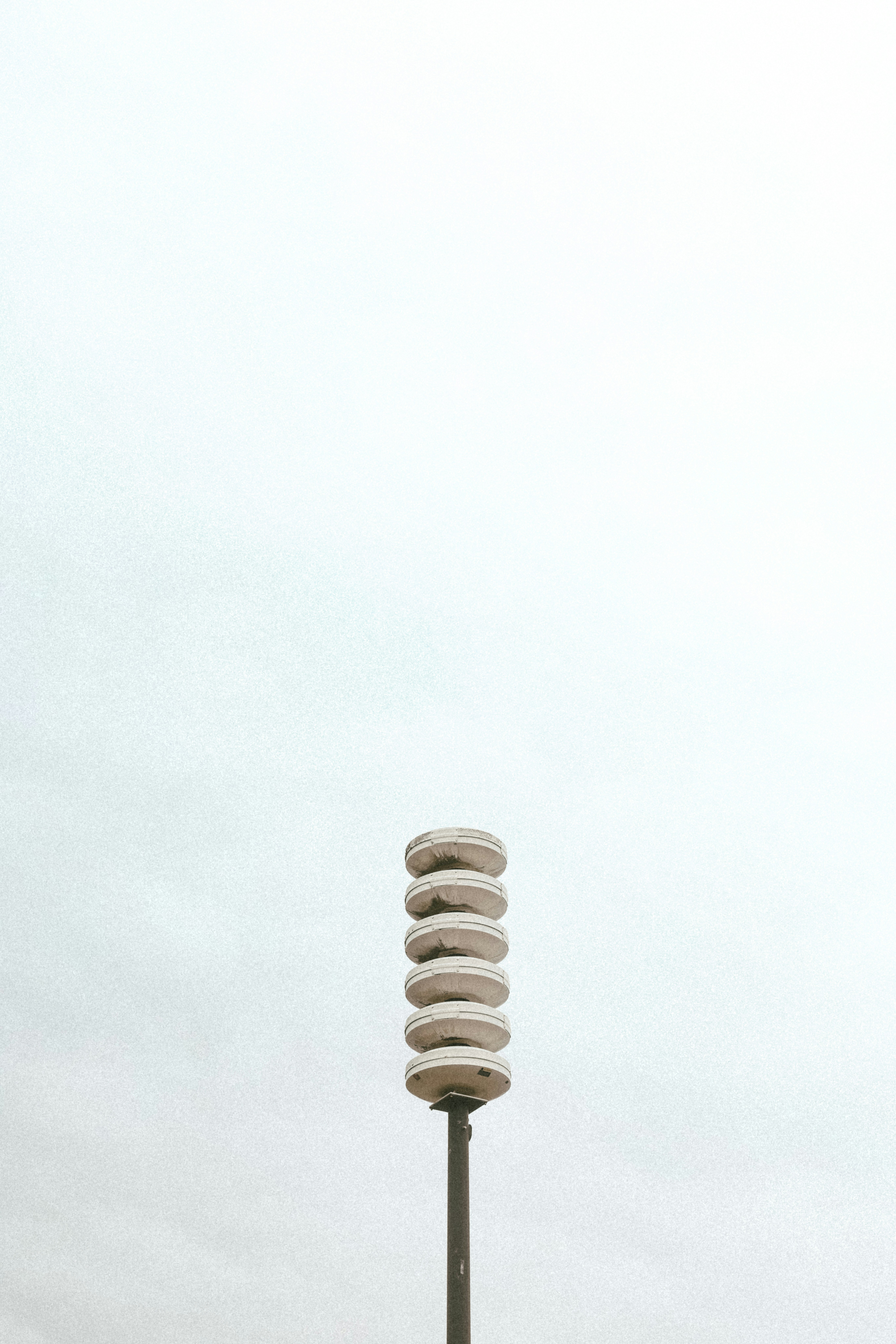 Six-Ring Beacon Rising Over a Pale Sky