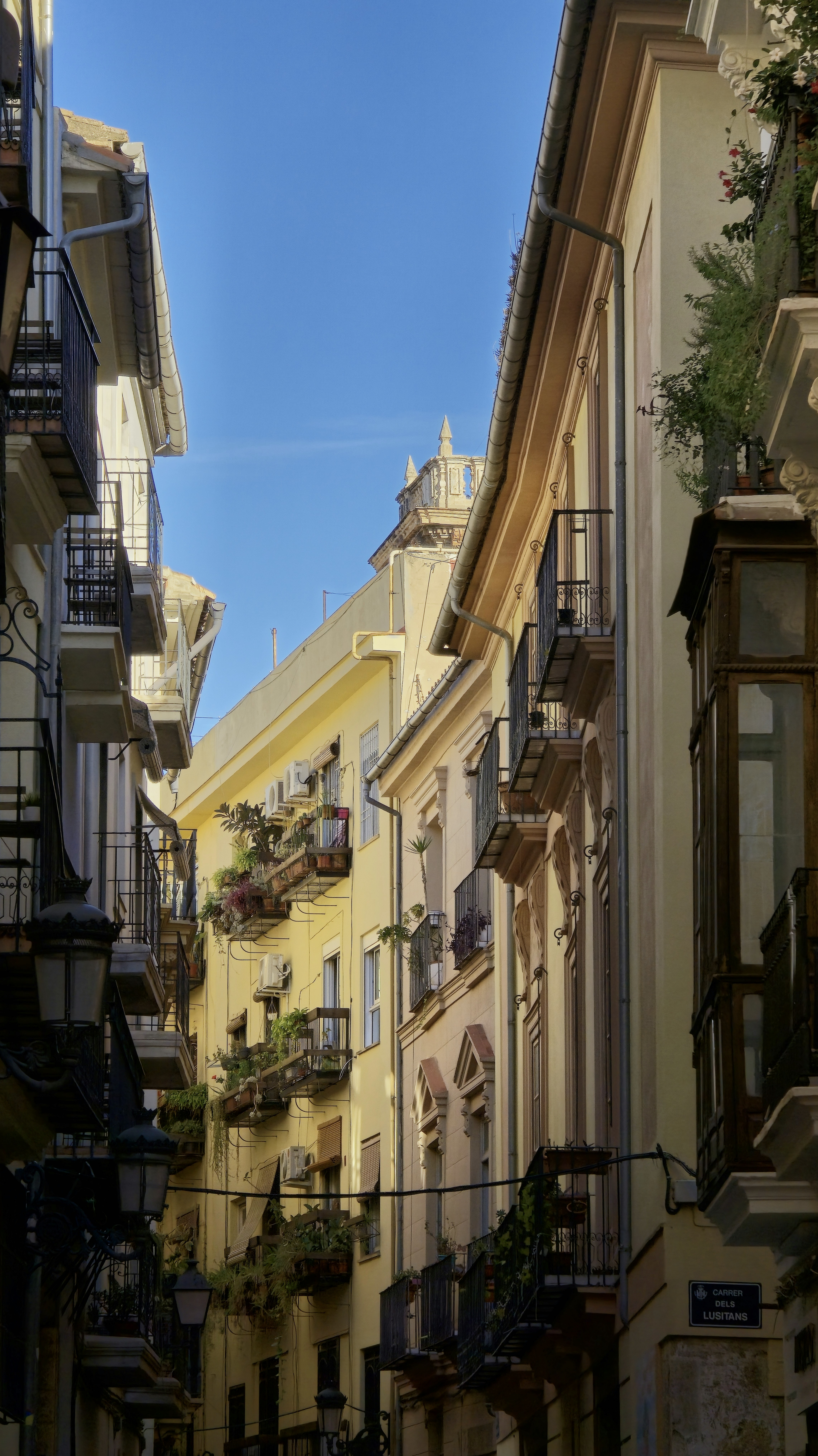 A narrow city street lined with tall buildings photo – Free Valencia ...