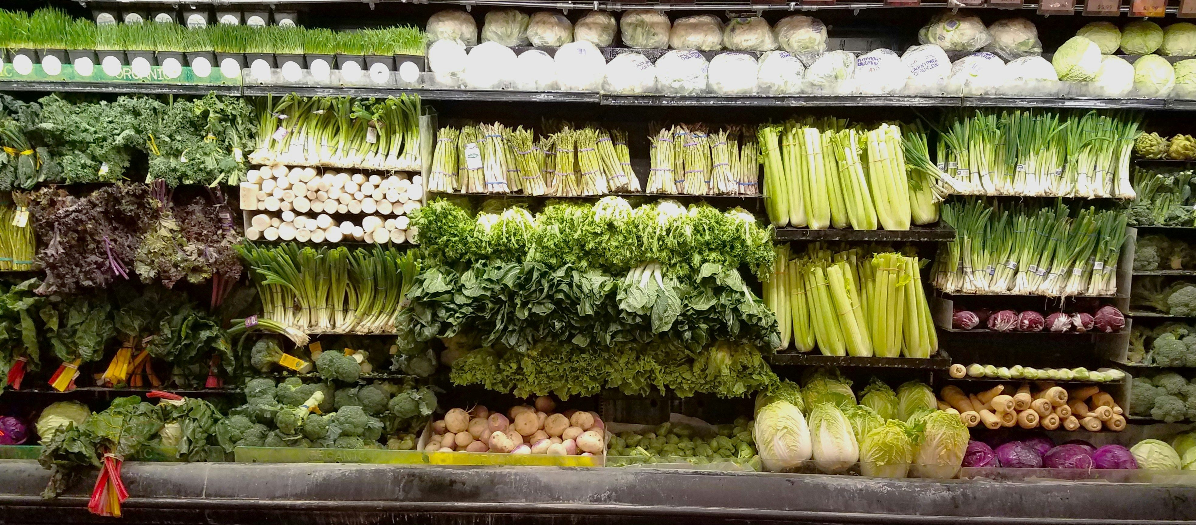 Verdant Symmetry: Multilayered Produce Display Under Grocery Aisle Lighting