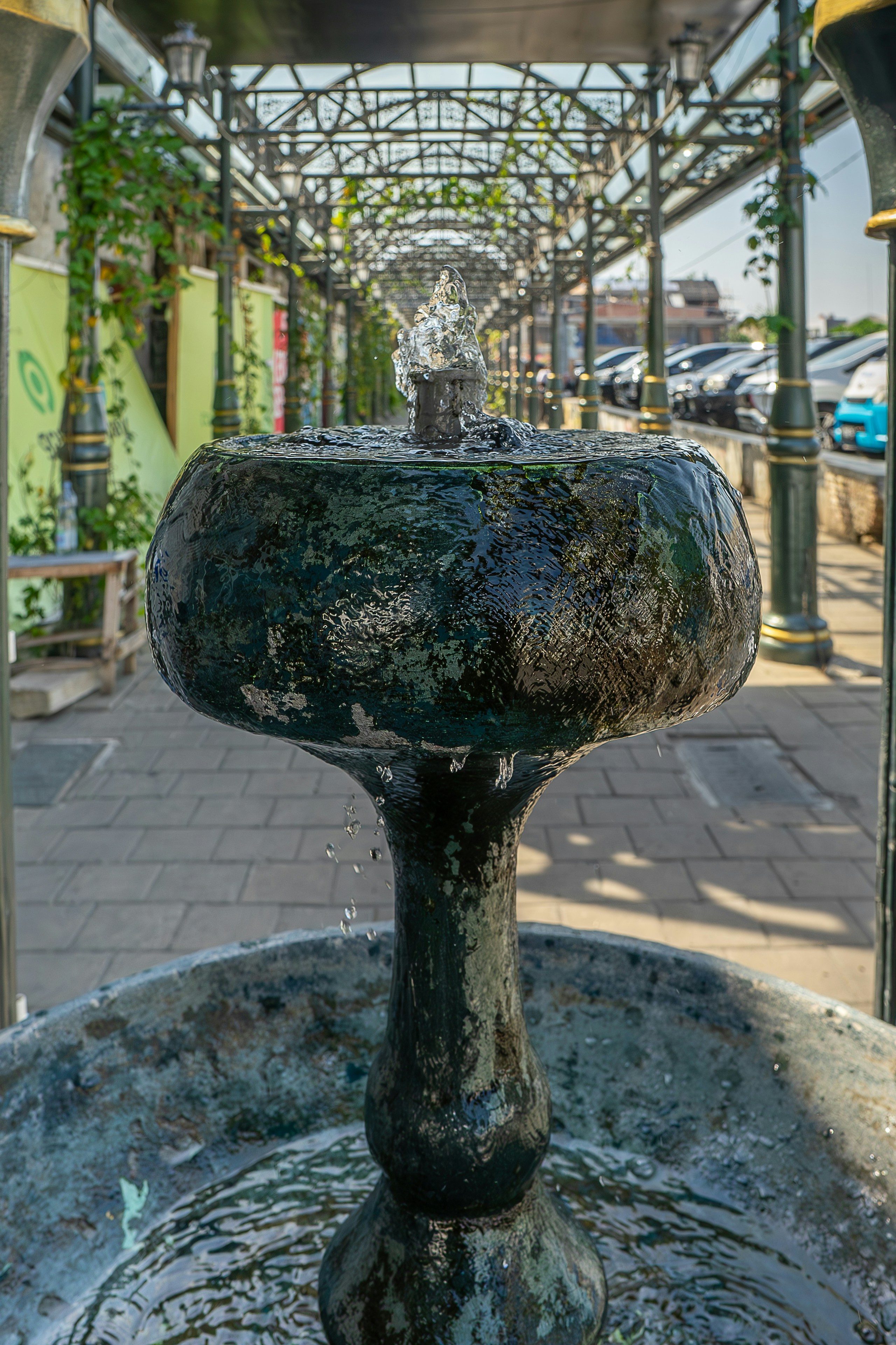 Weathered Fountain Head at the Heart of a Sunlit Arcade