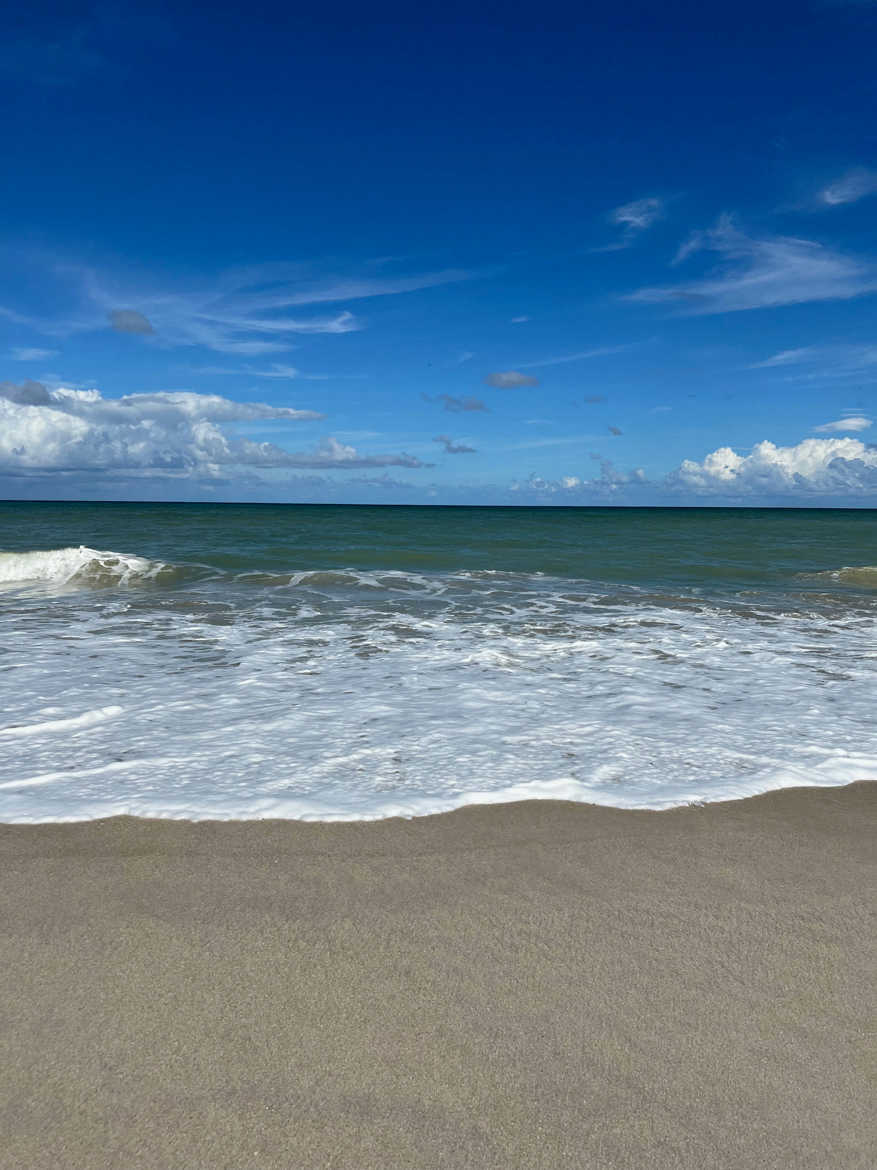 A sandy beach with waves coming in to shore photo – Free Beach Image on ...