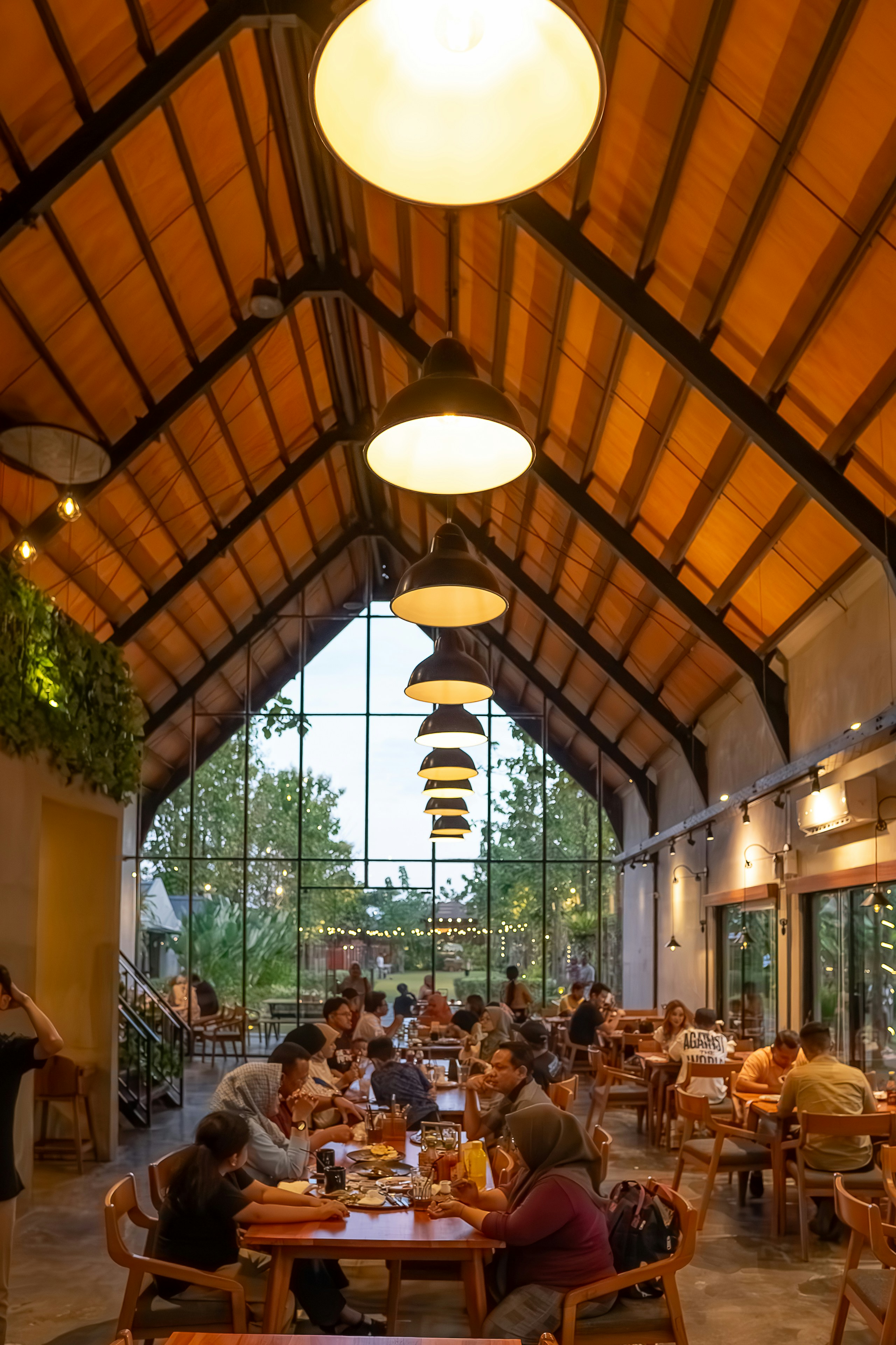Aisle of Warm Lamps Under Timber Vaults in a Glass-Walled Café