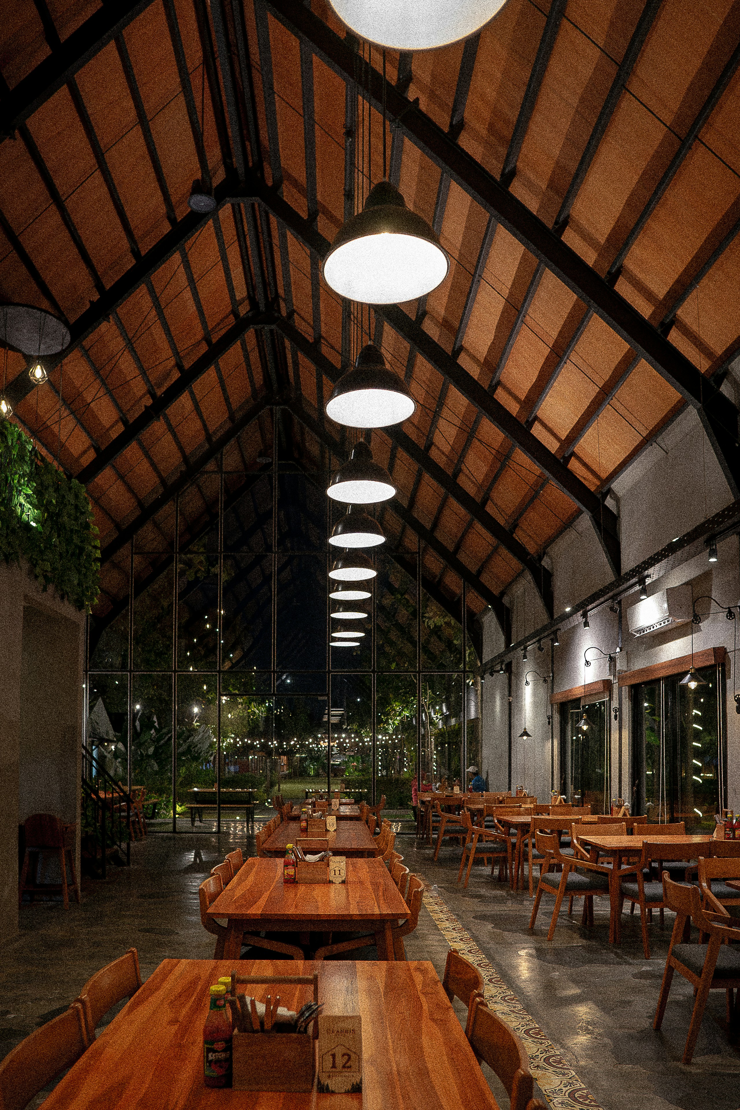 Lanterns Over Timber Vault: Evening in a Glass-Walled Bistro