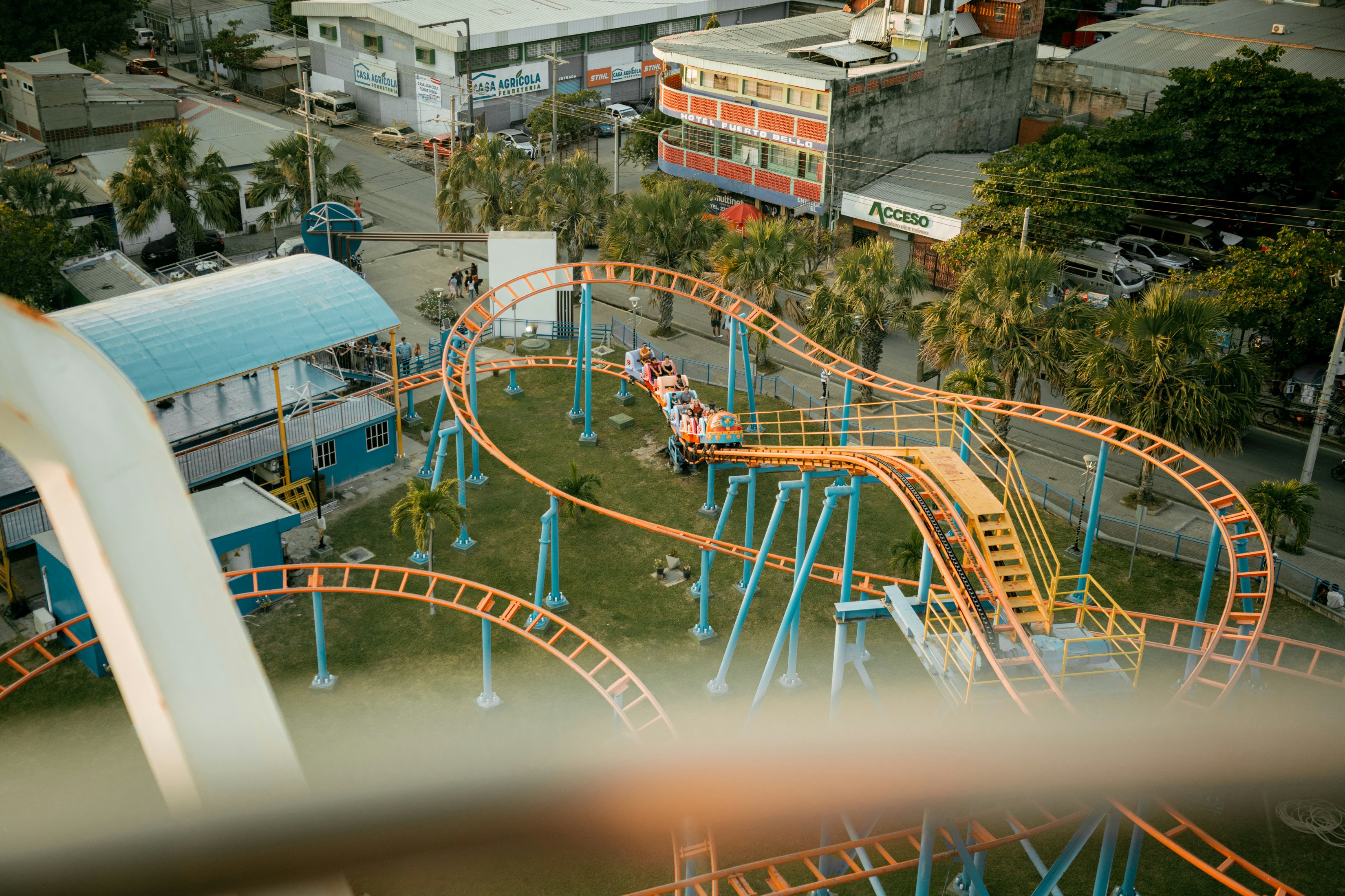 Orange Ribbon Coaster: Aerial Tangle Over a City Park