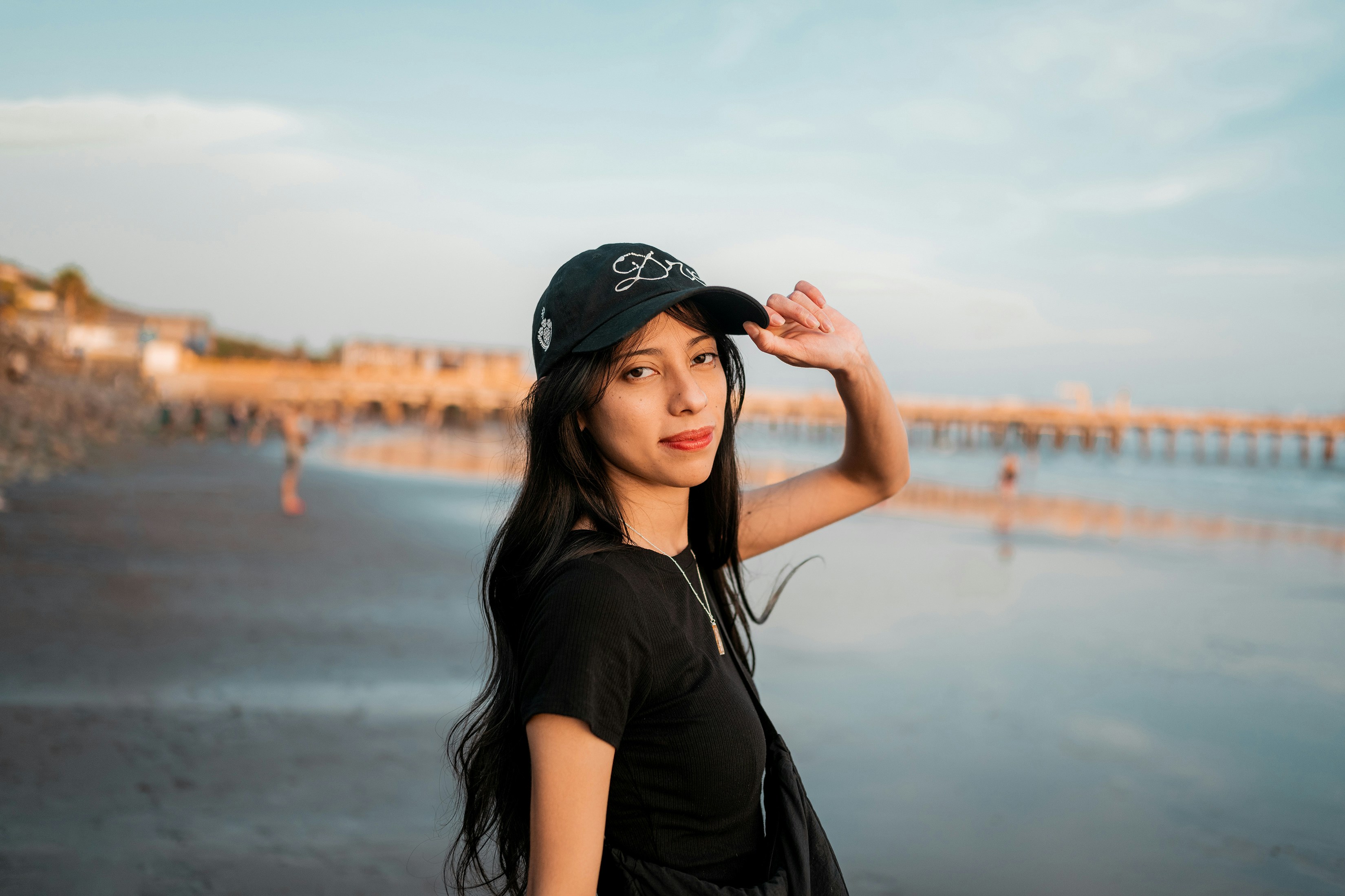 A woman standing on a beach next to the ocean