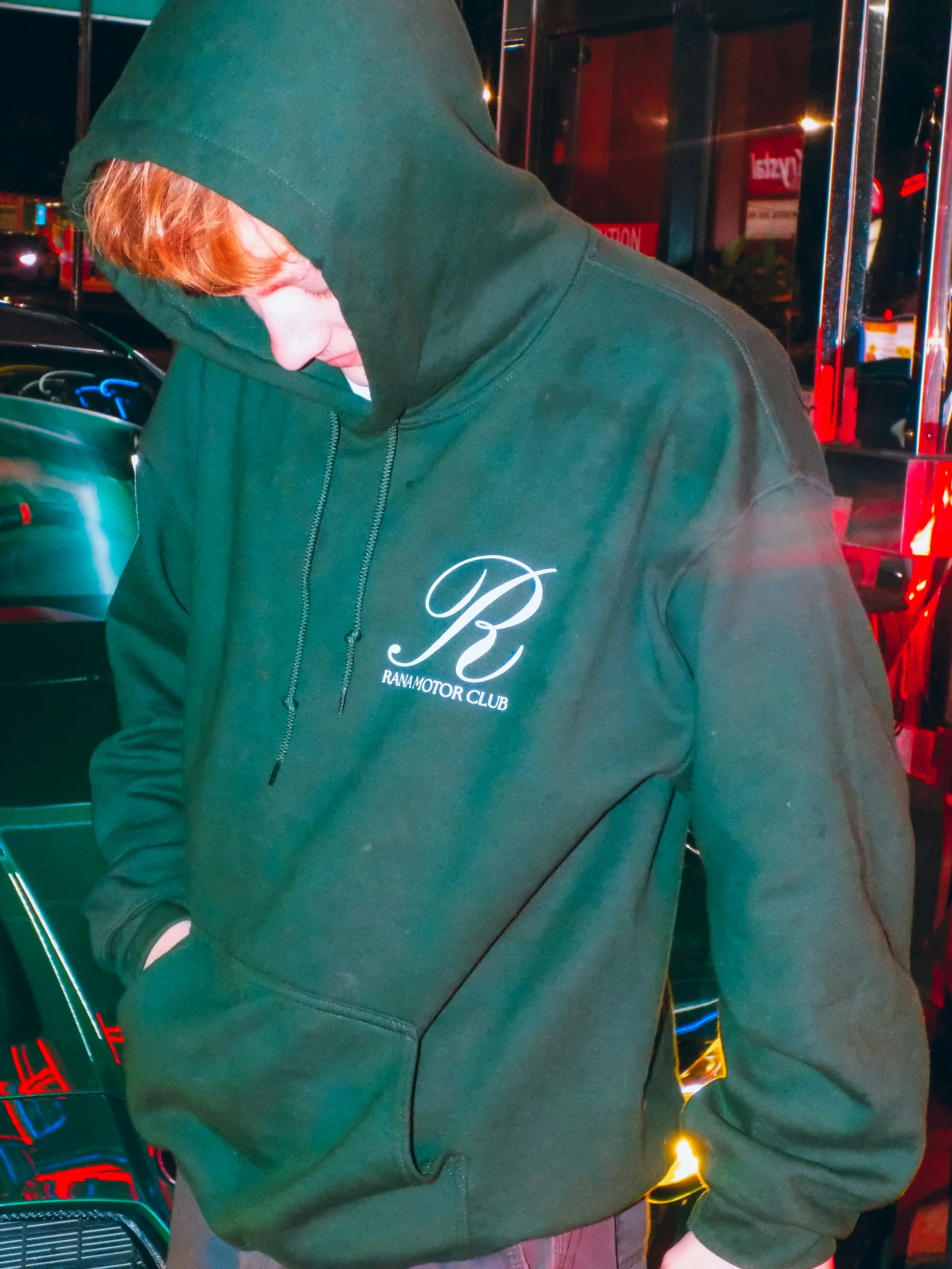 Neon Quiet: A Green-Hooded Figure Under City Lights