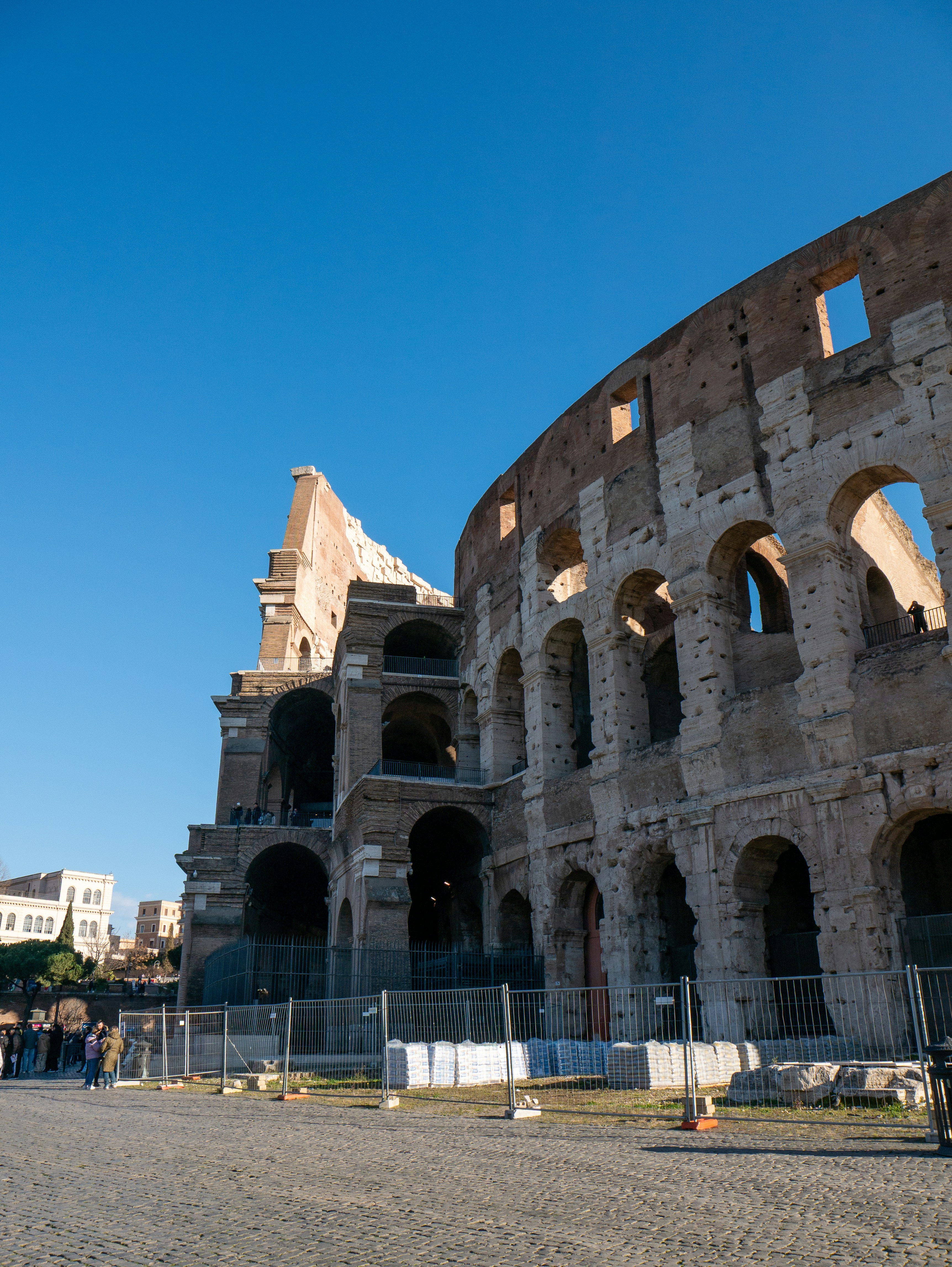 Colosseum Under Blue Sky: Ancient Walls and Modern Barriers