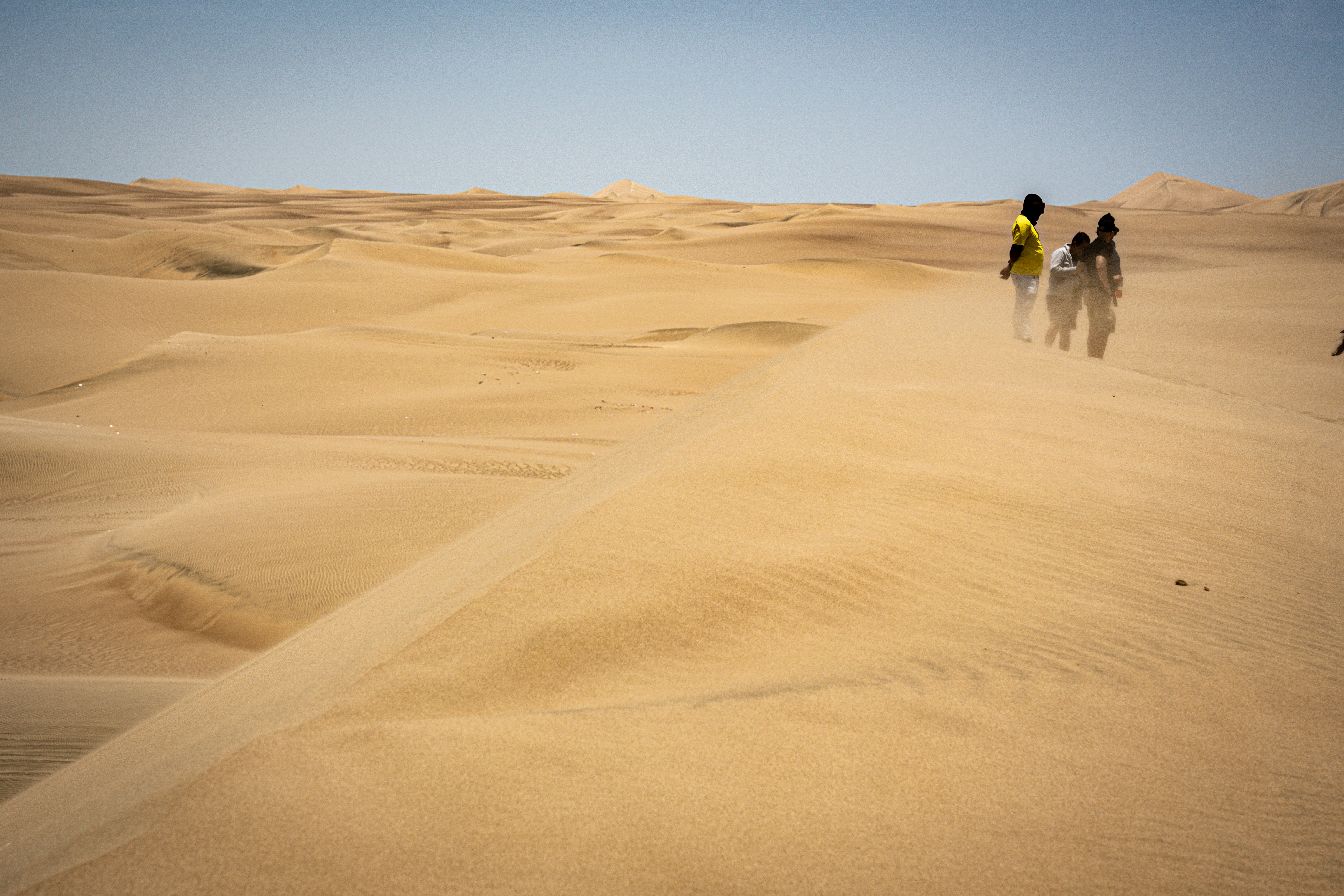 A group of people walking across a sandy field photo – Free Peru Image ...
