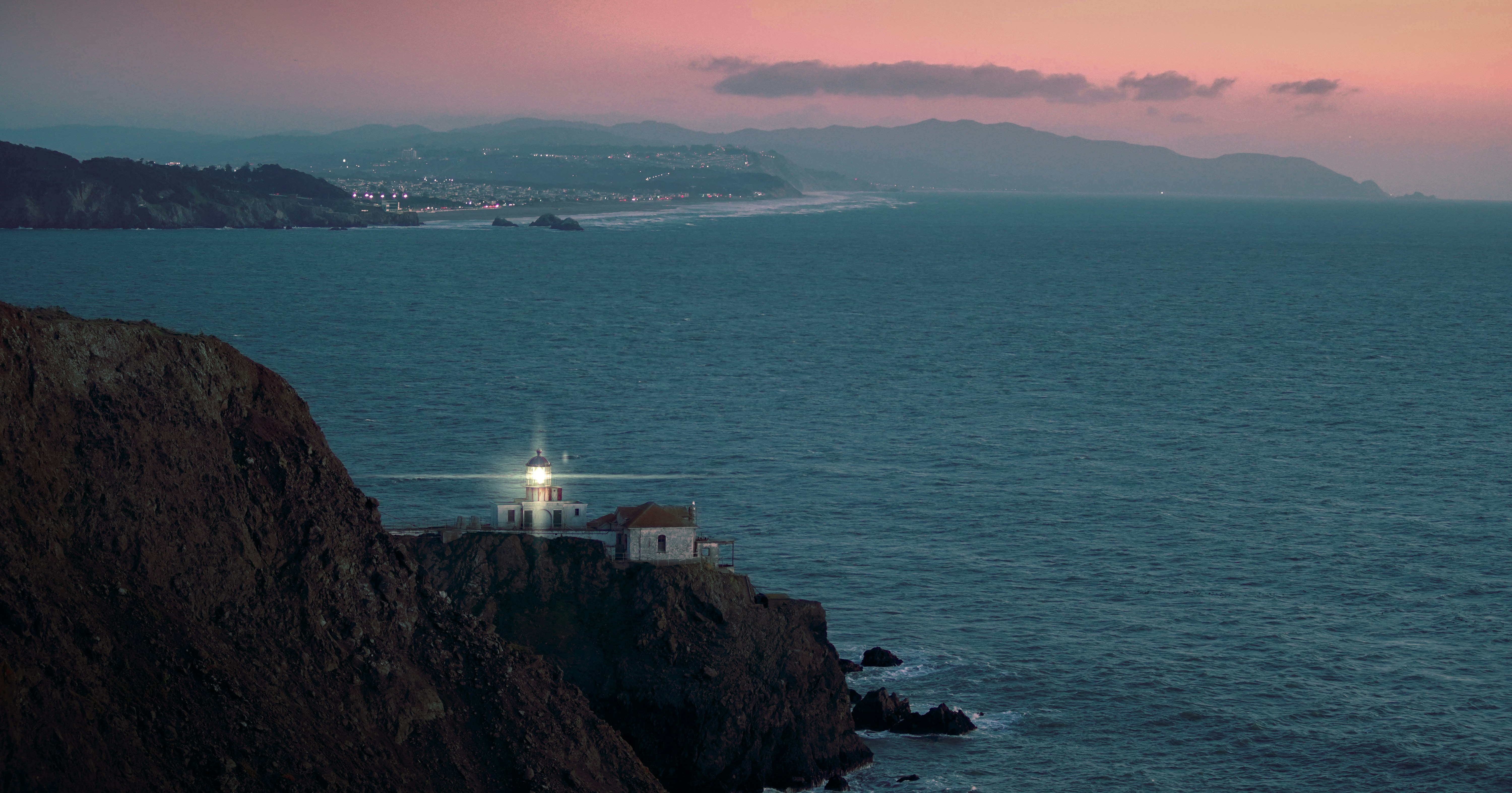 A lighthouse on a cliff overlooking the ocean photo – Free Nature Image ...