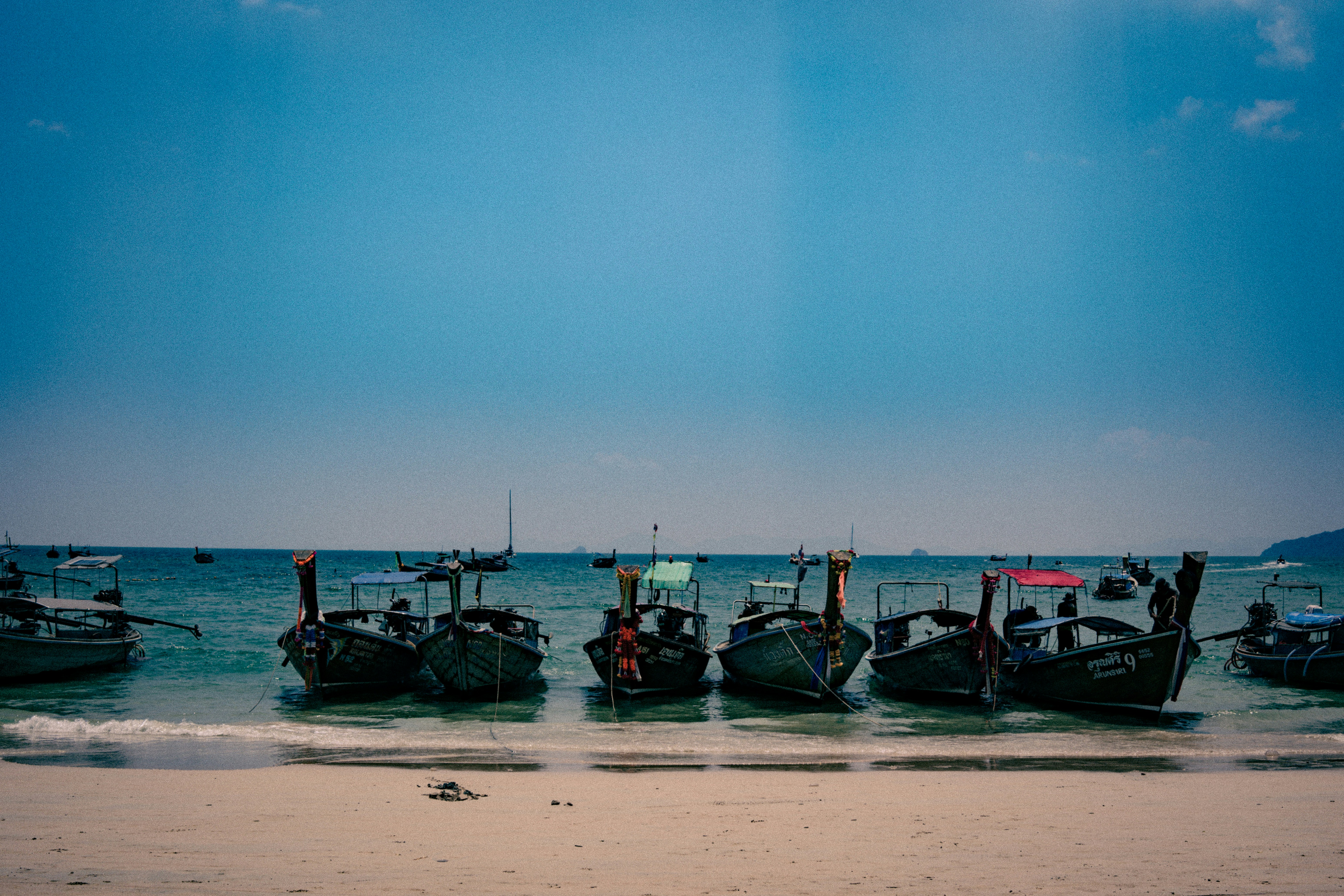 Harbor Lineup: Colorful Boats Rest Along a Quiet Seashore