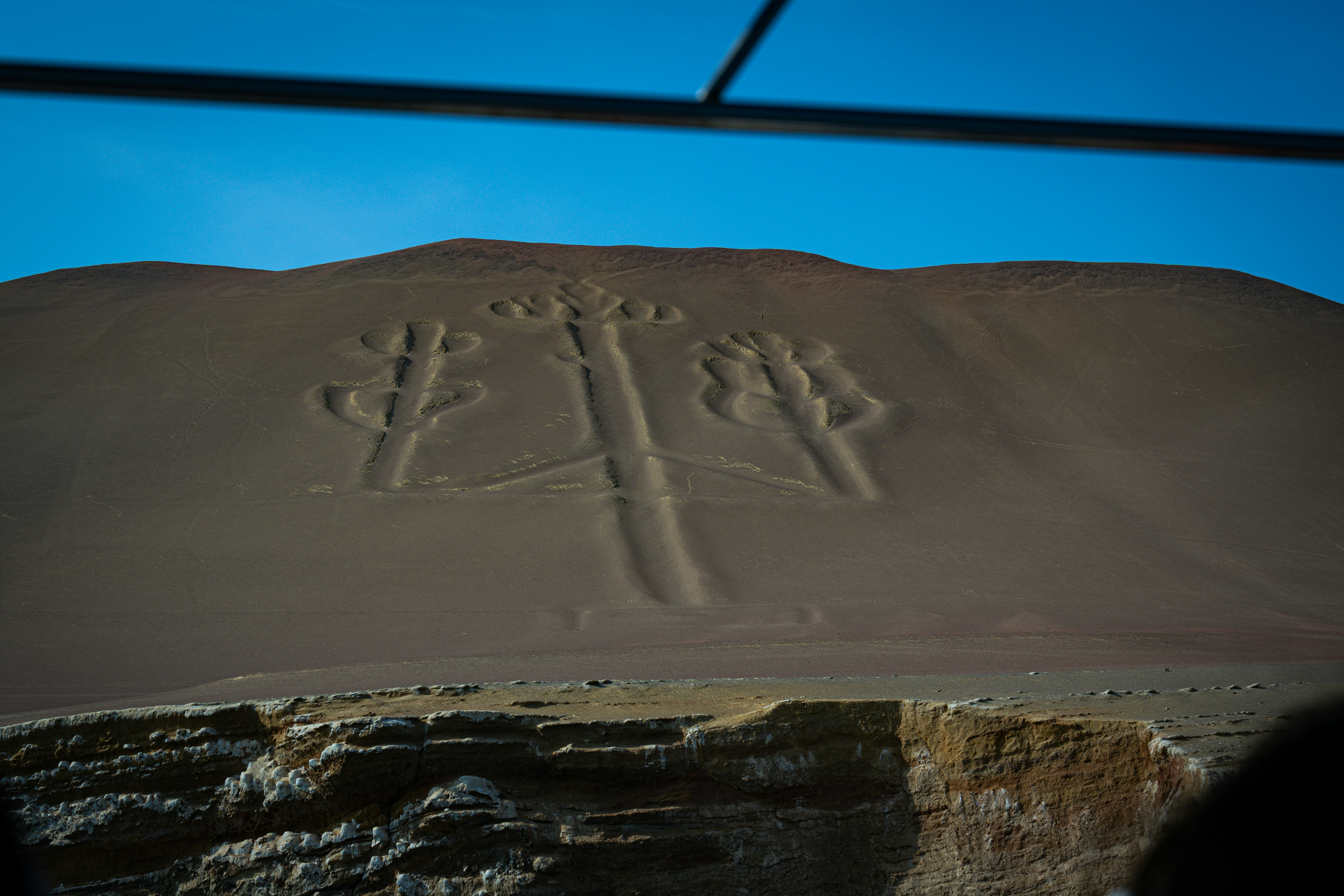 Carved into Dust: A Desert Glyph Near a Glassy Horizon
