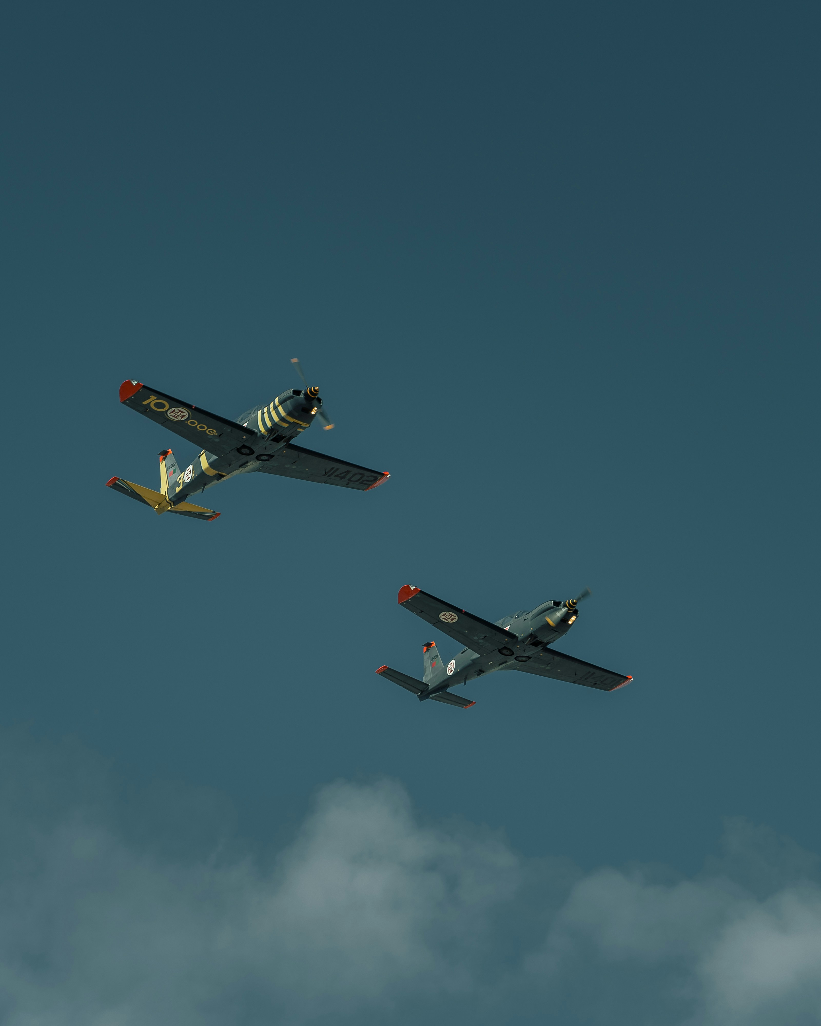Two airplanes flying in the sky with clouds in the background photo ...