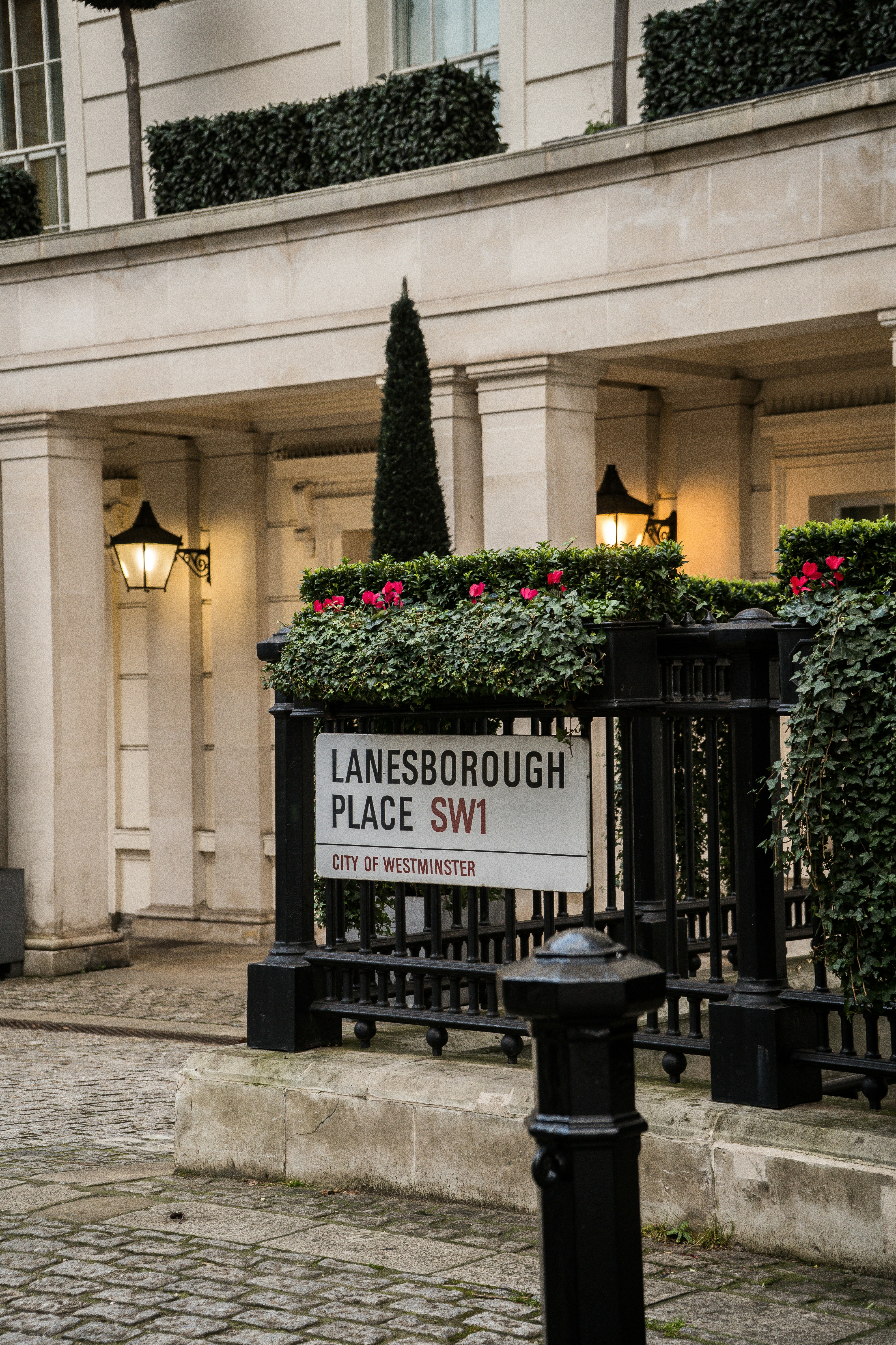 Lanesborough Place Sign Framed by Iron Railings, Lantern Light, and Ivy
