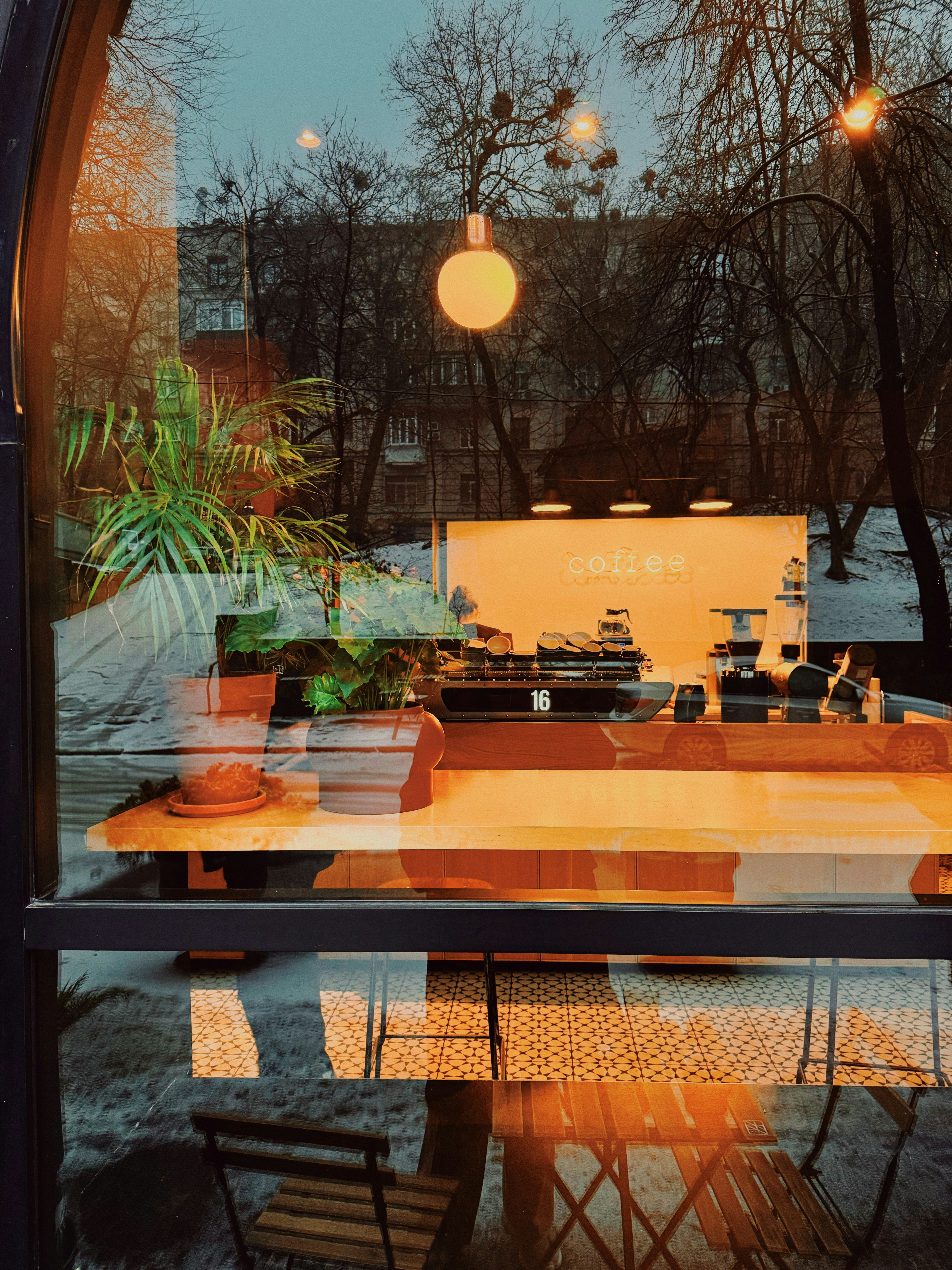 Through the Glass: Warm Café Glow Framed by a Snowy Street