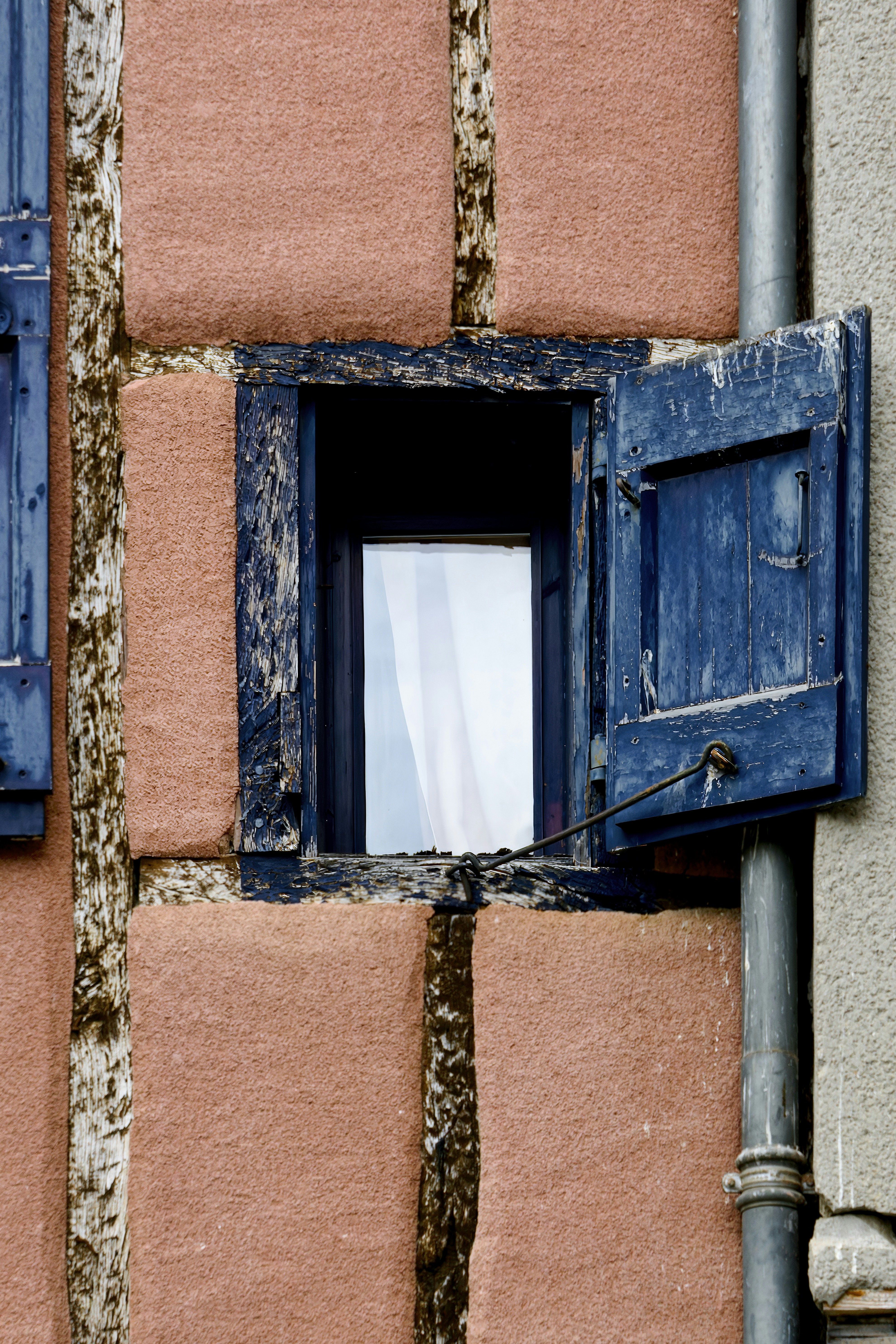 Time-Worn Blue Window: A Narrow Sliver of Light in a Textured Wall