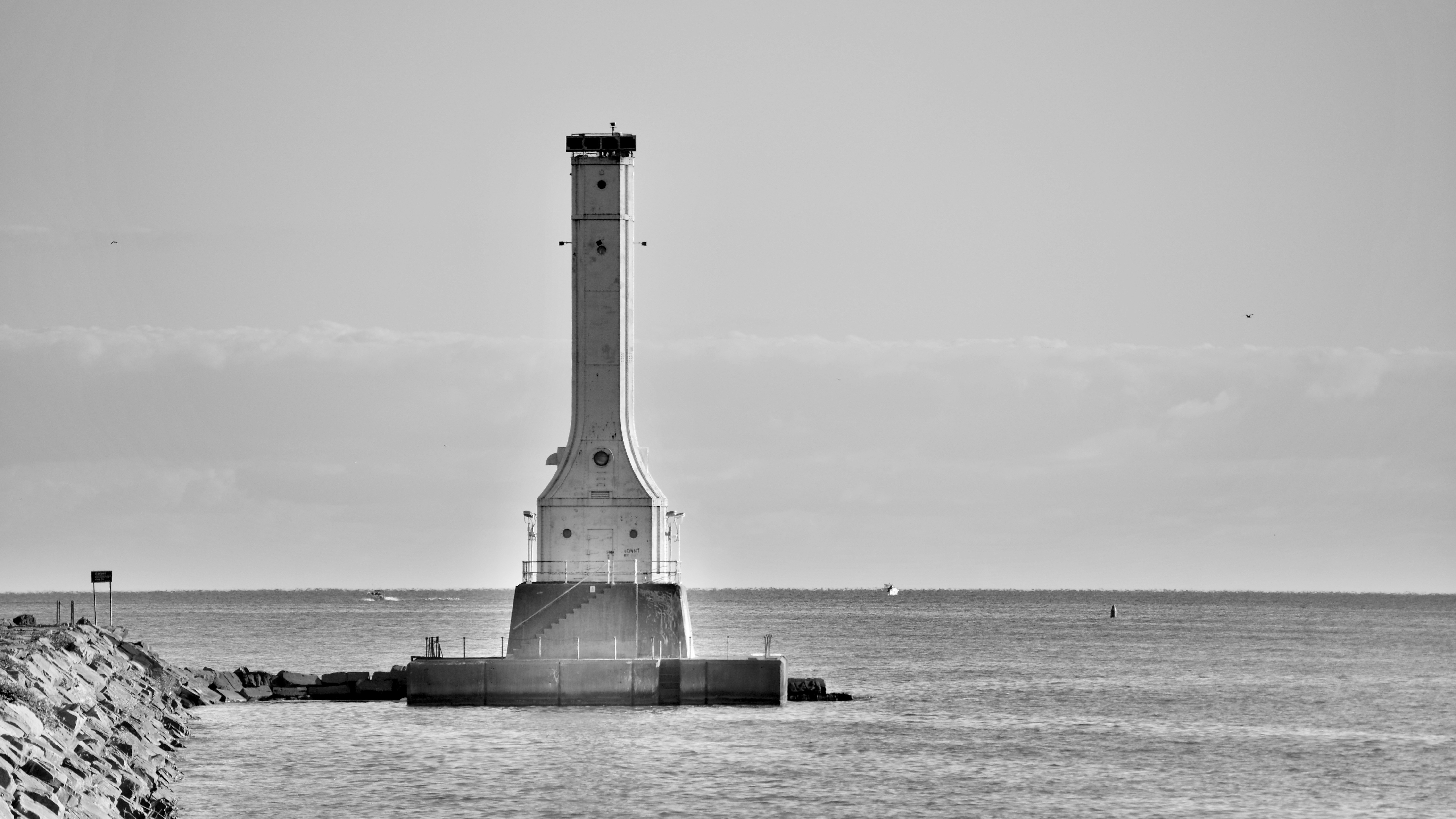 Monochrome Sentinel: Lighthouse Standing Guard Over a Quiet Sea