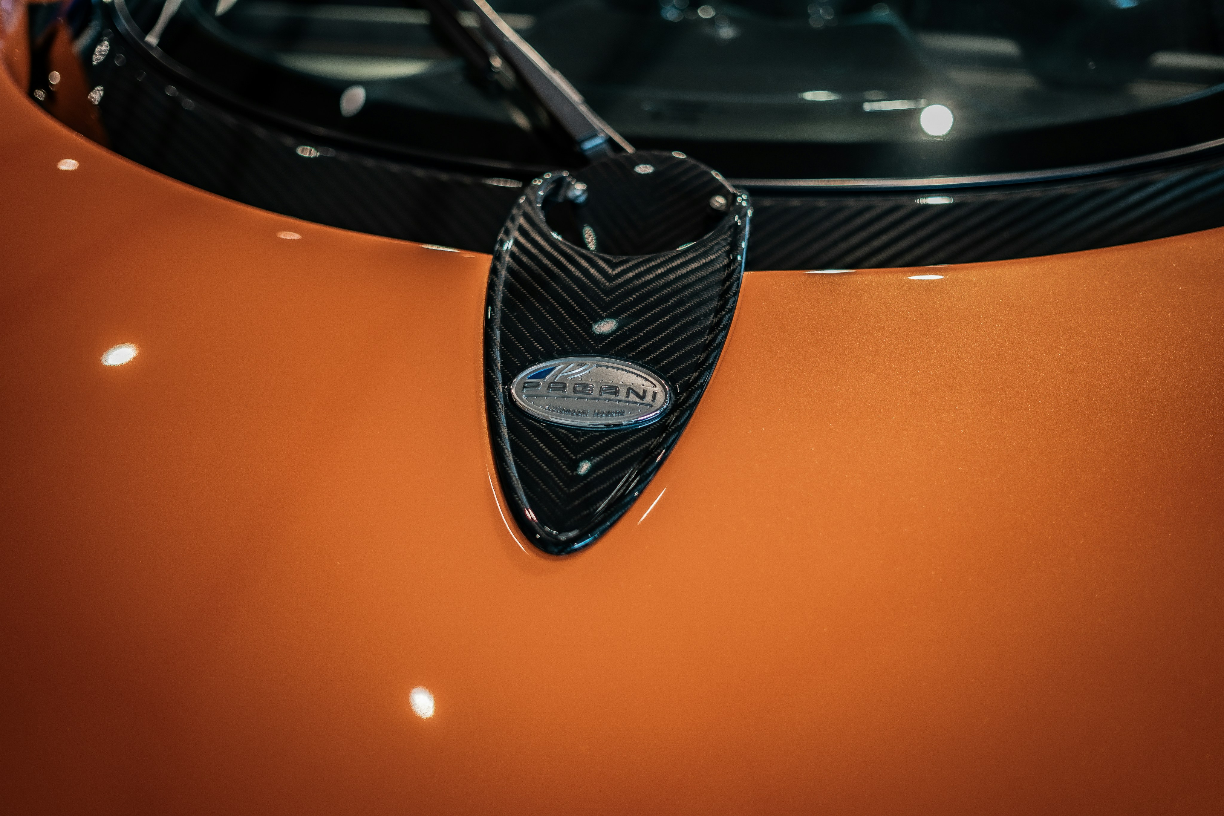 Carbon-Fiber Crest on Citrus Hood: A Close-Up of Nissan's Emblem