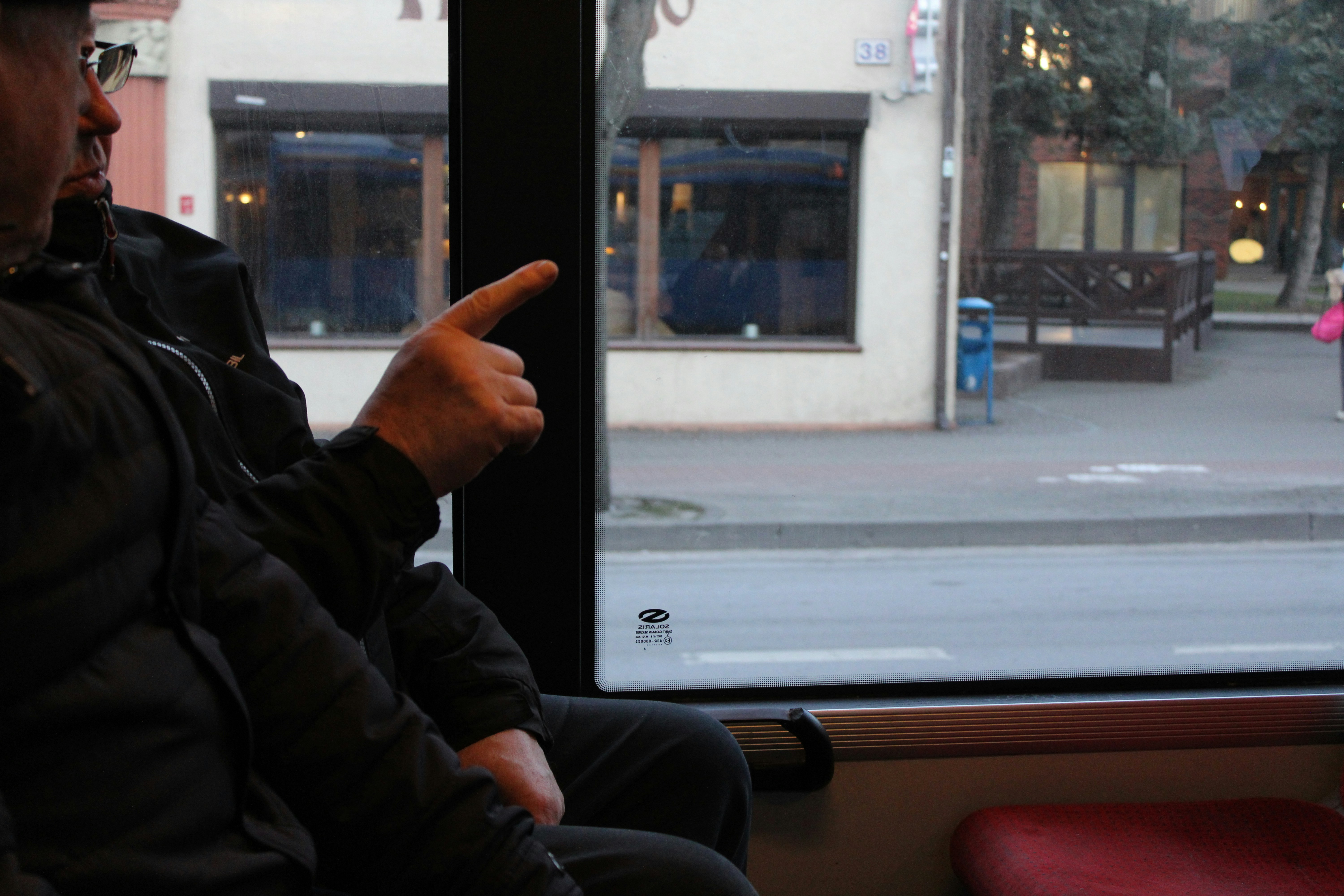 A man sitting on a bus pointing at something photo – Free Lithuania ...