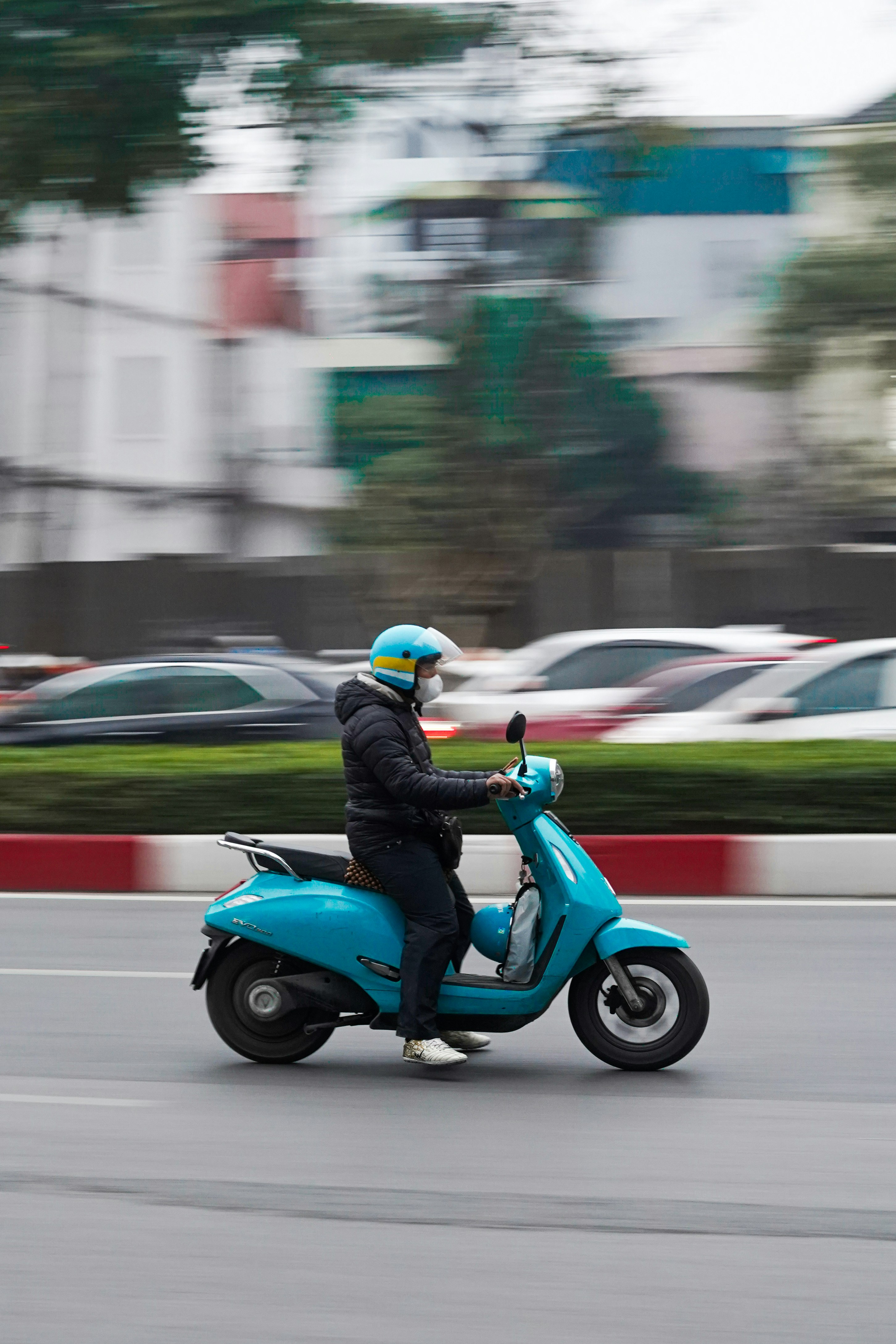 Azure Scooter in City Motion: A Turquoise Streak Amid Urban Blur