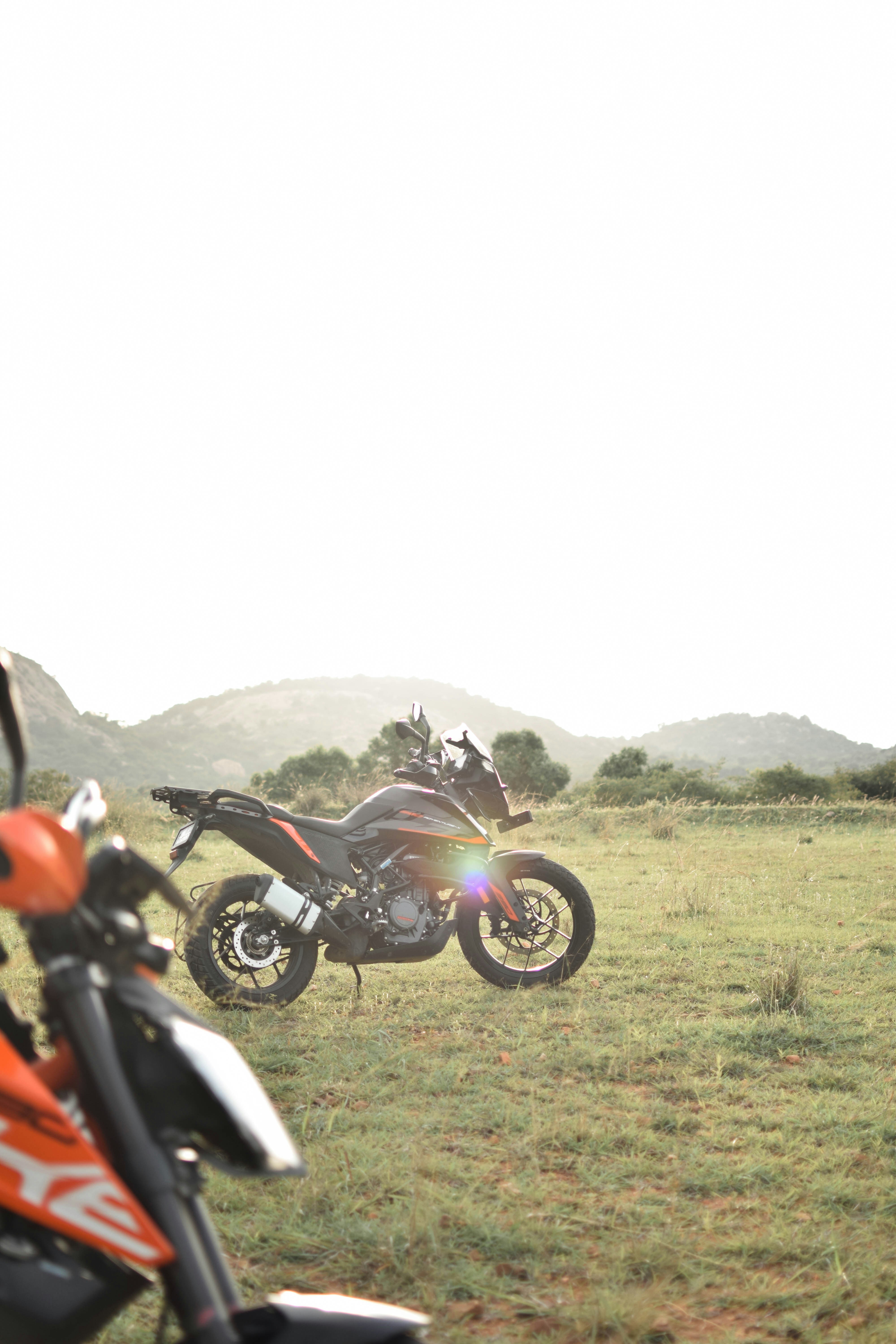 A couple of motorcycles parked in a field photo – Free Karnataka Image ...