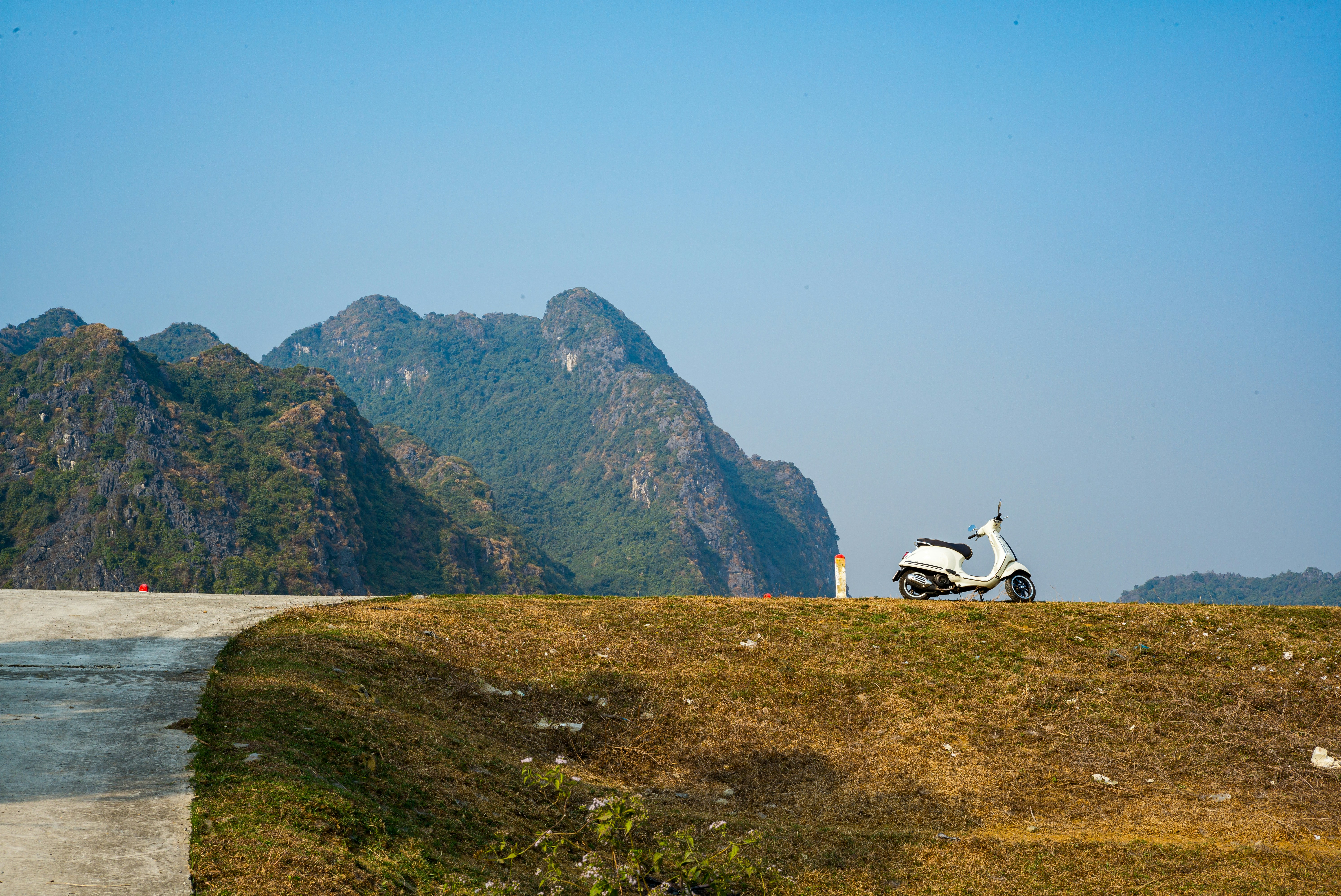 A Lone Scooter at the Edge of a Rolling Ridge