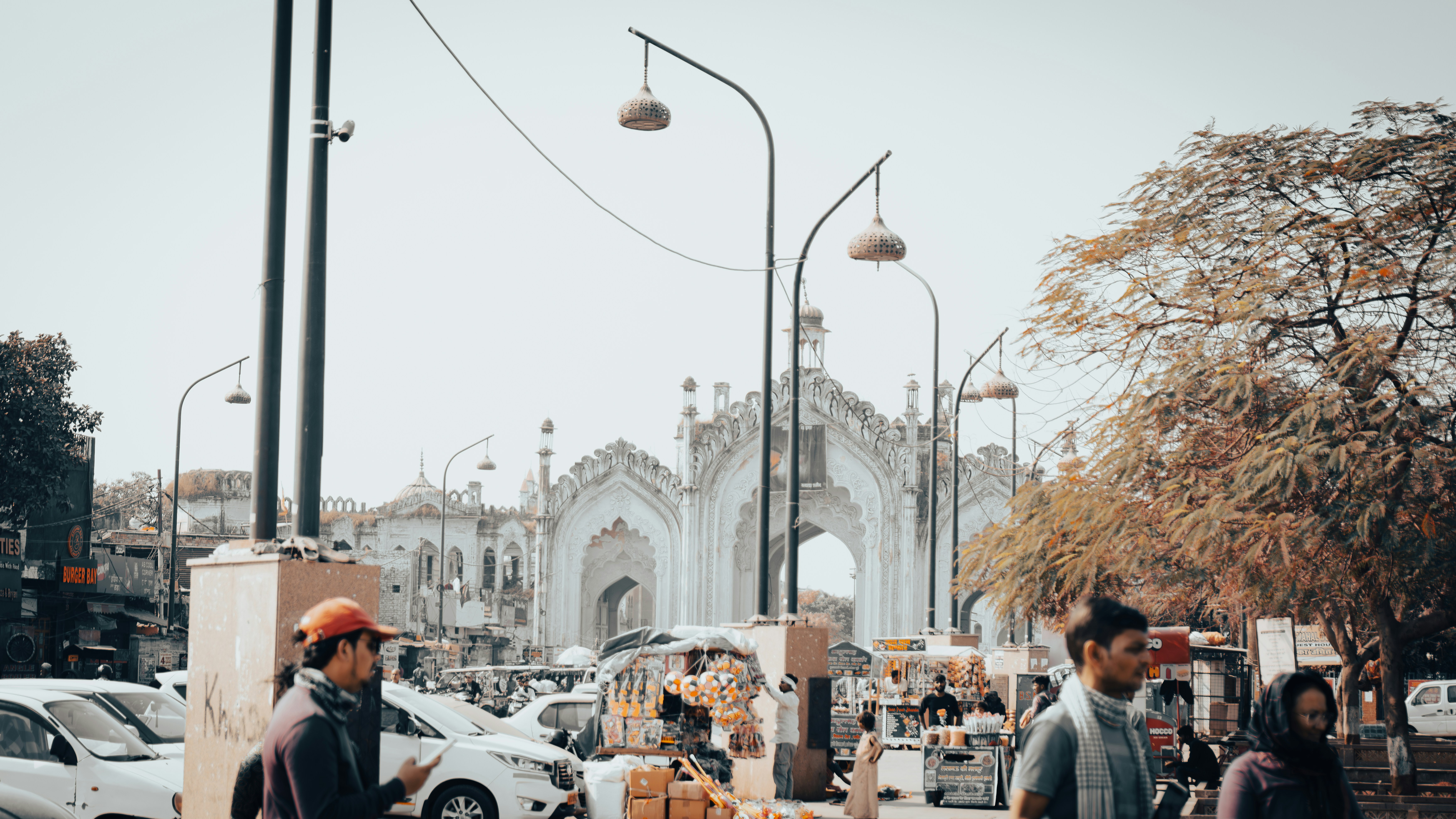 Ornate Arch Over a Lively Street Market at Dusk