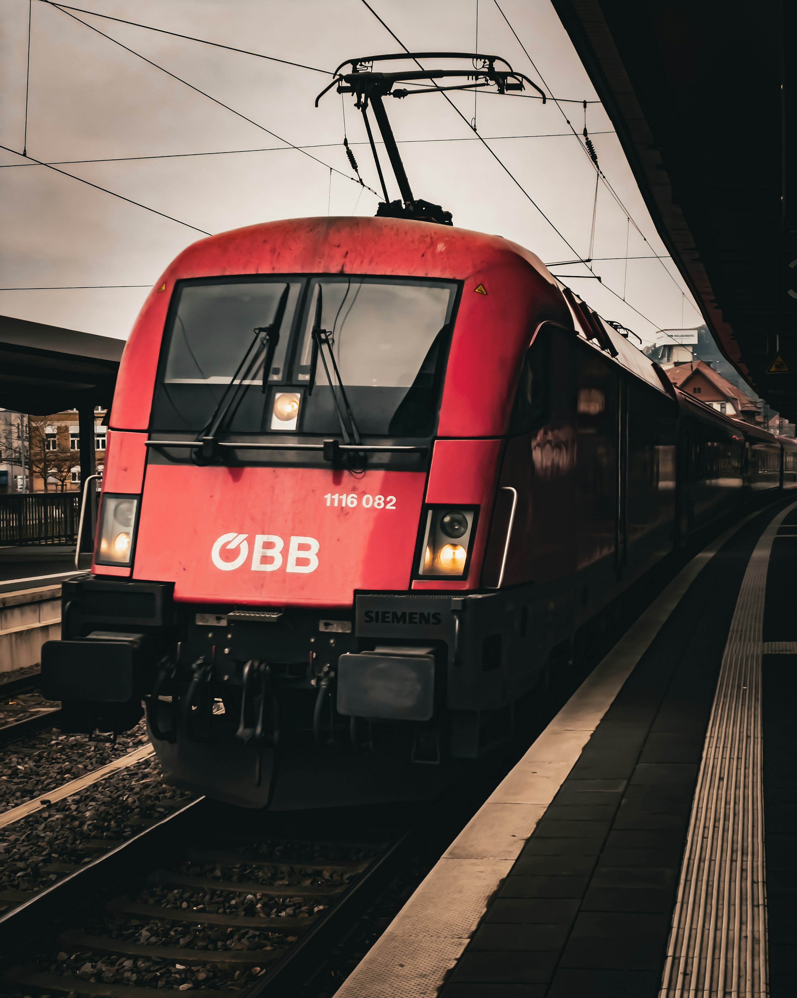 A red train pulling into a train station photo – Free Travel Image on Unsplash