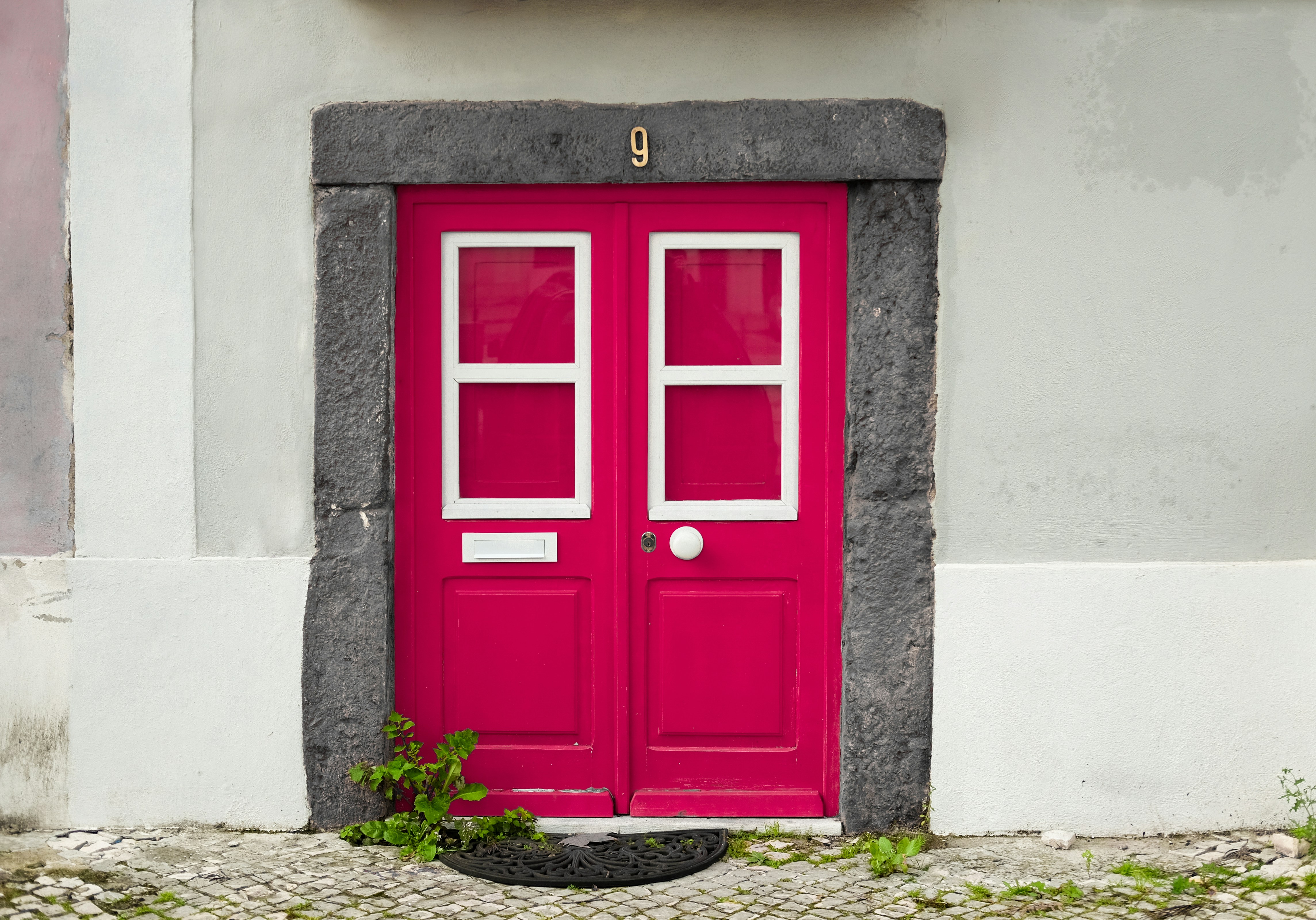 A red door in front of a white building